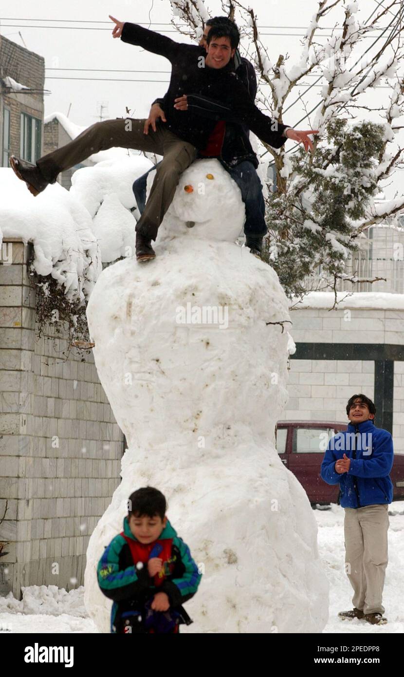 Iranian boys pose with a snowman in Tehran on Tuesday Feb. 8, 2005 ...