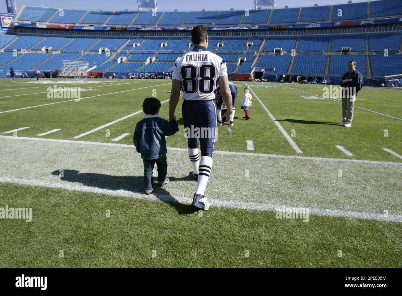 New England Patriots tight end Christian Fauria (88) walks with his son ...