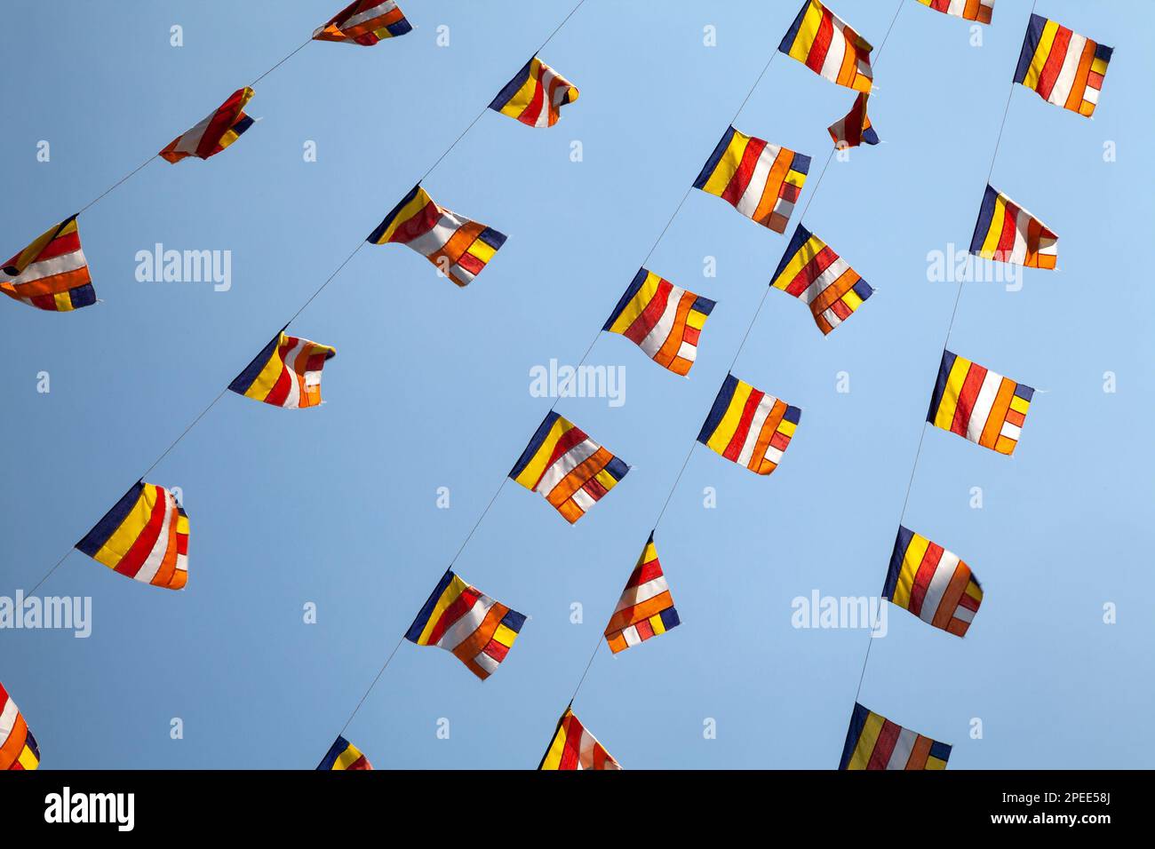 Many colorful Buddhism flags flown in the sky in a pagoda in Vietnam ...
