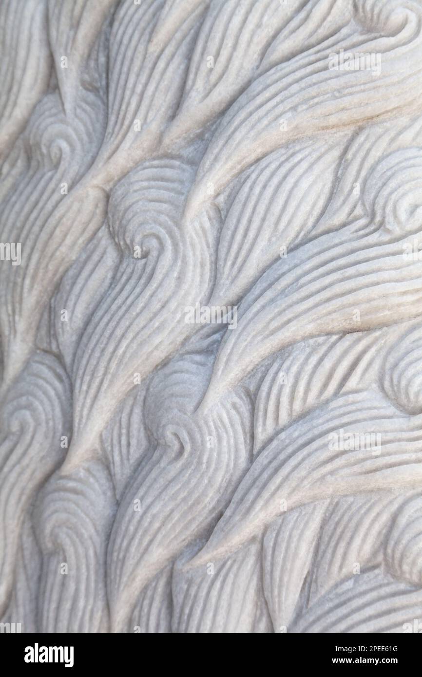 Animal fur curly waves pattern carved in stone close-up. White ...