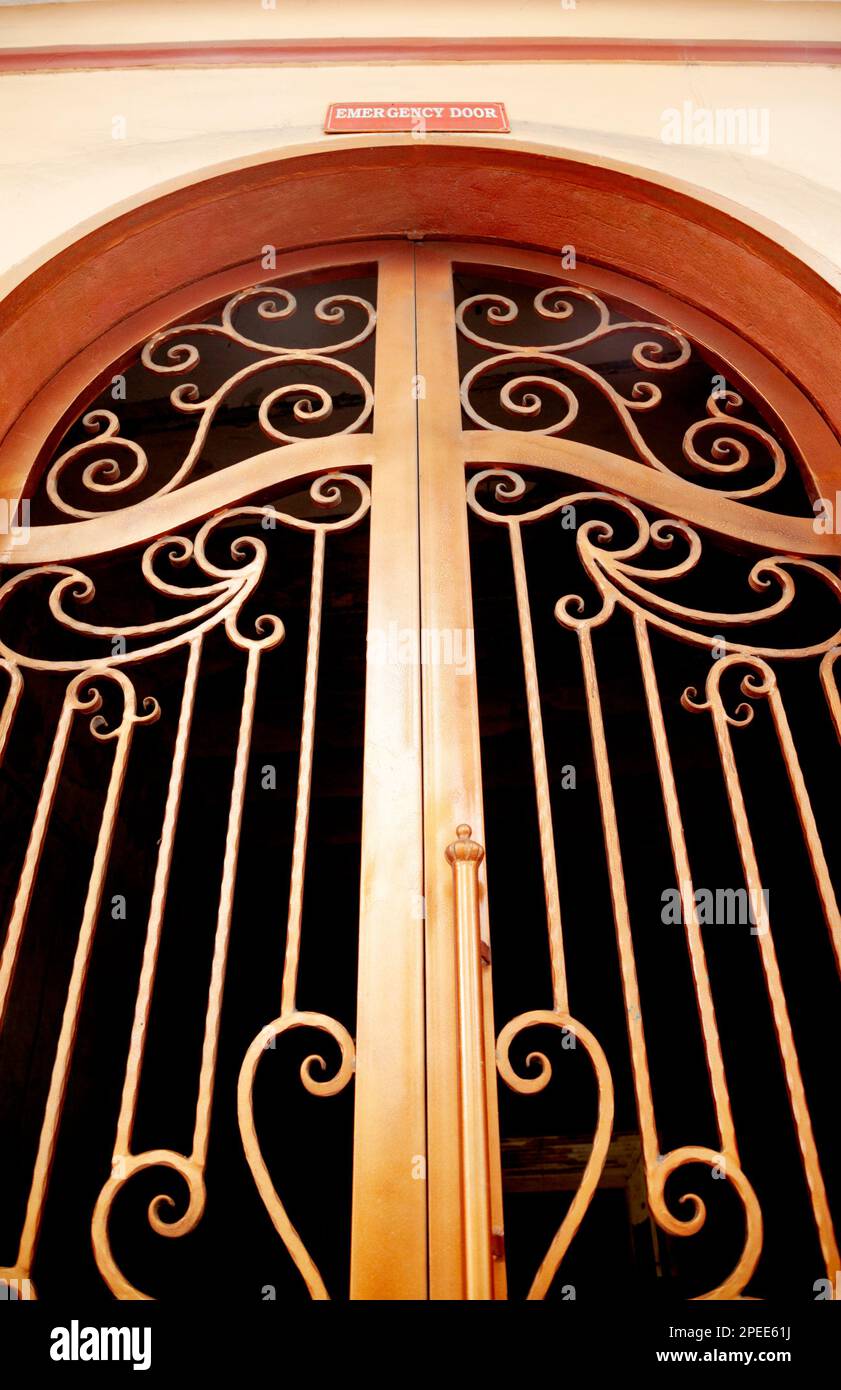 Ornate metal doors of emergency exit with a sign on it. Decorative gate ...