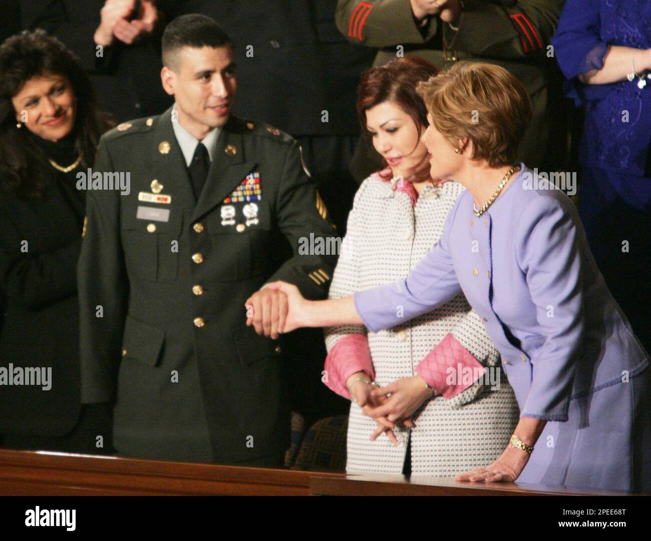First Lady Laura Bush, right, shakes the hand of Army Staff Sergeant ...