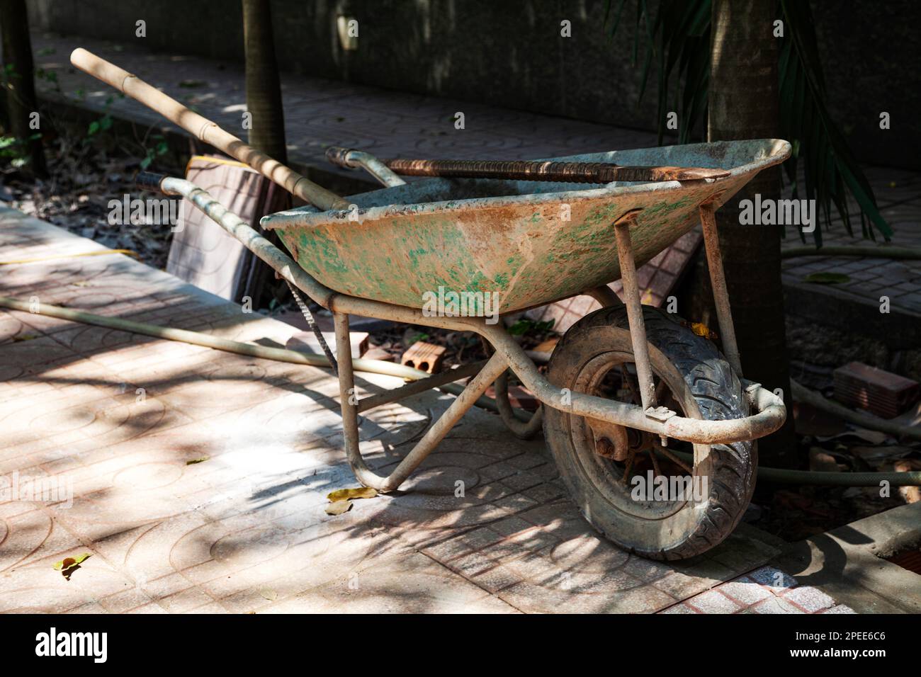 Dirty old wheelbarrow with tools in it left at a construction site ...