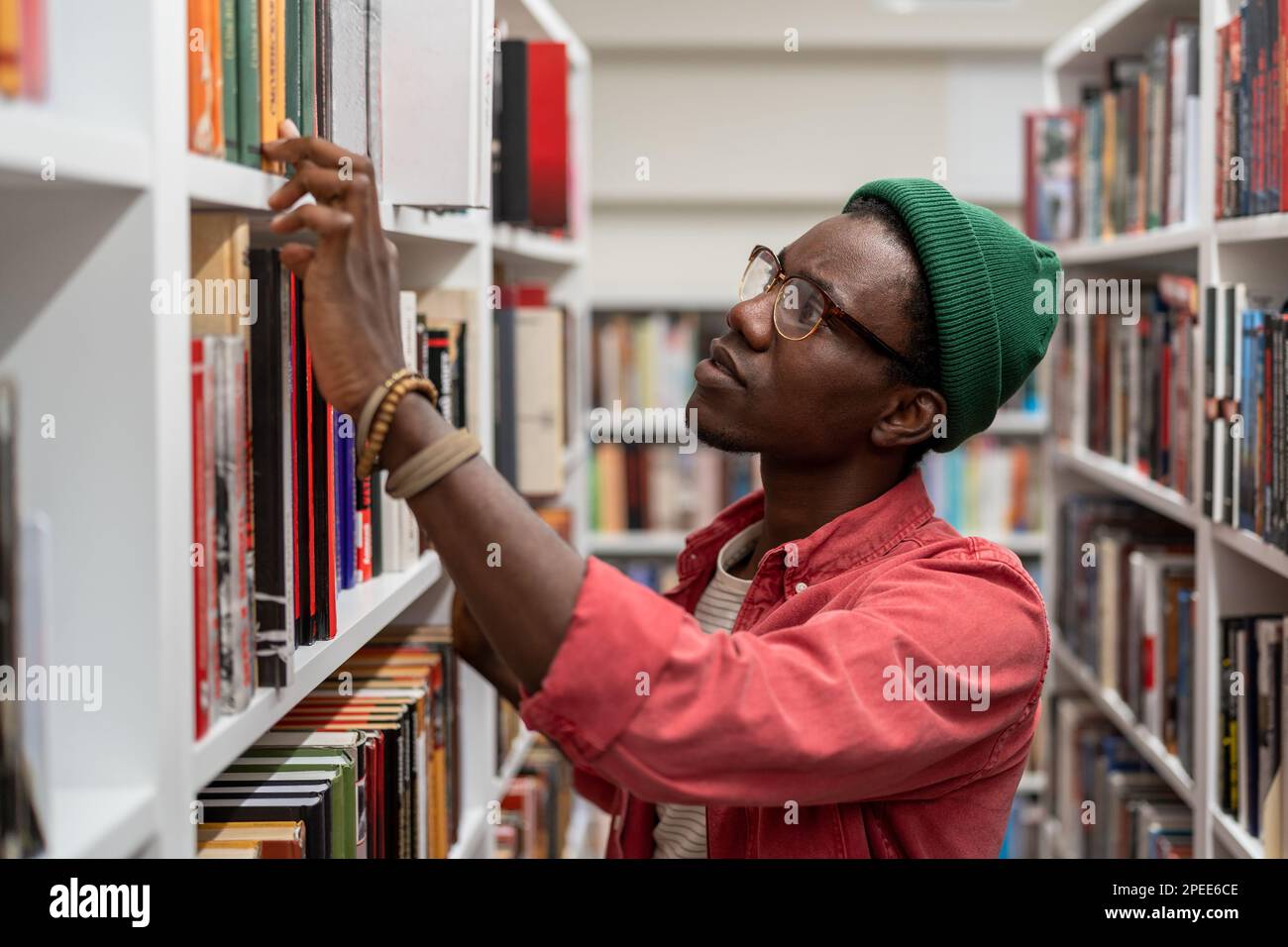 Puzzled concentrated black man student choosing need literature for ...