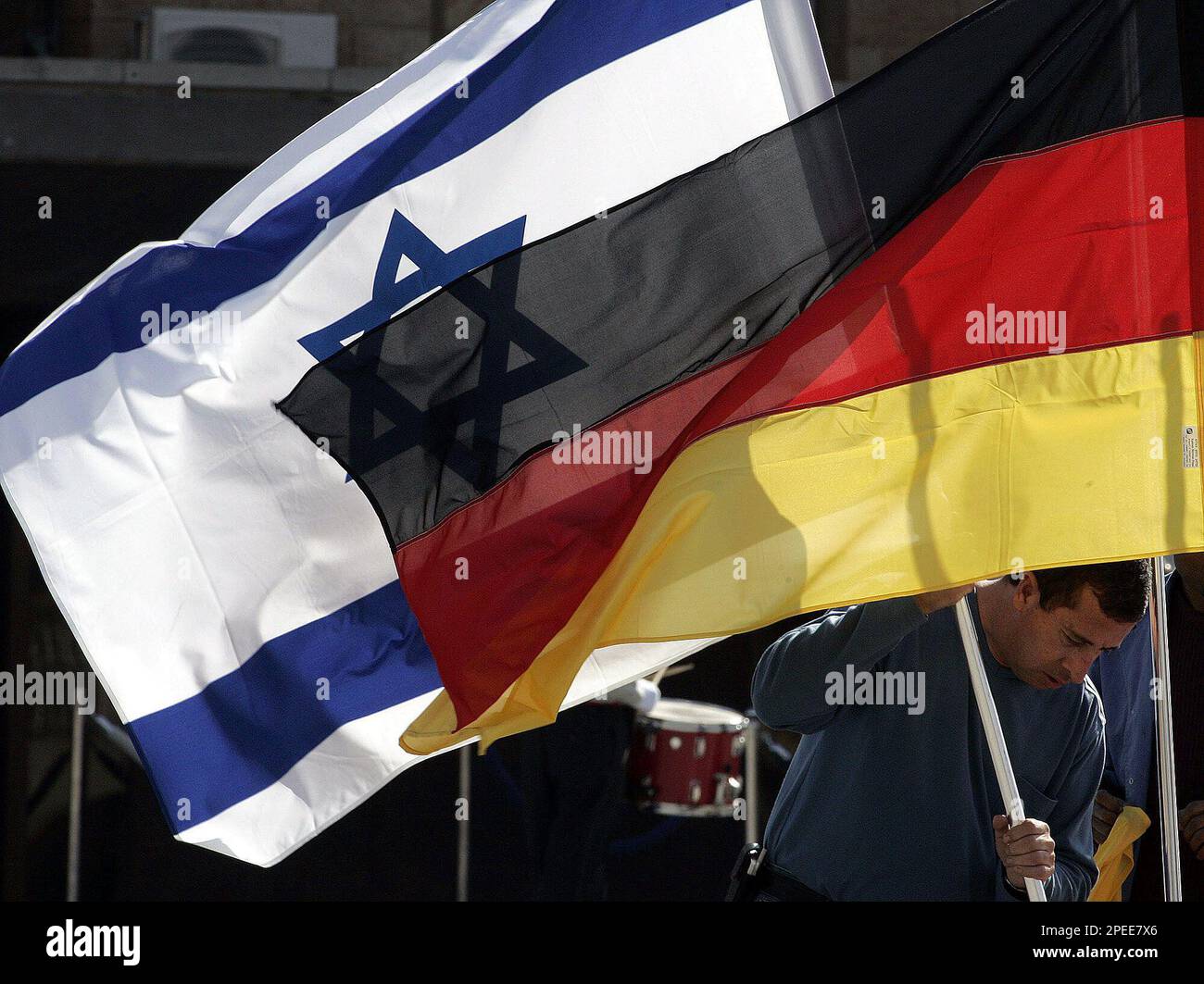 A worker prepares an Israeli, left, and a German, right, flag in front ...