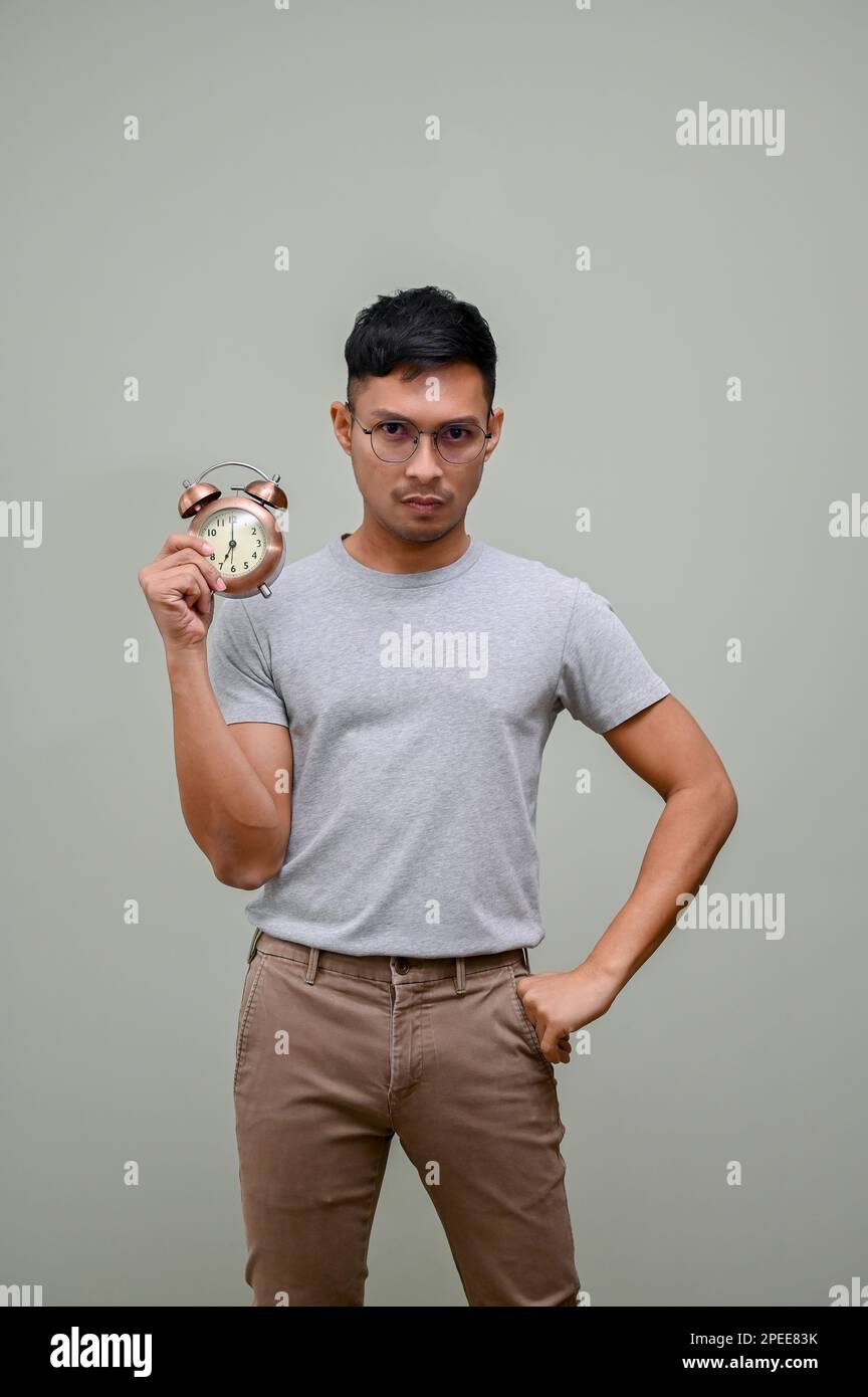 Serious and stressed millennial Asian man in casual clothes and glasses ...