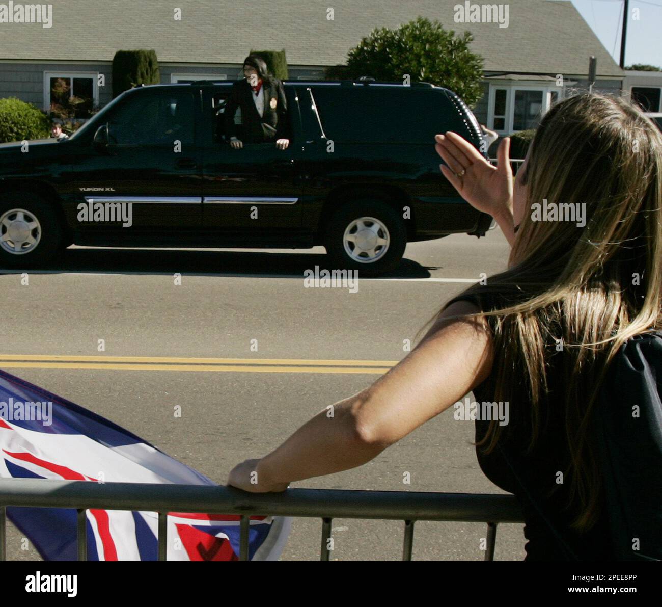 Michael Jackson leans out of the window of his SUV to wave to his fans ...