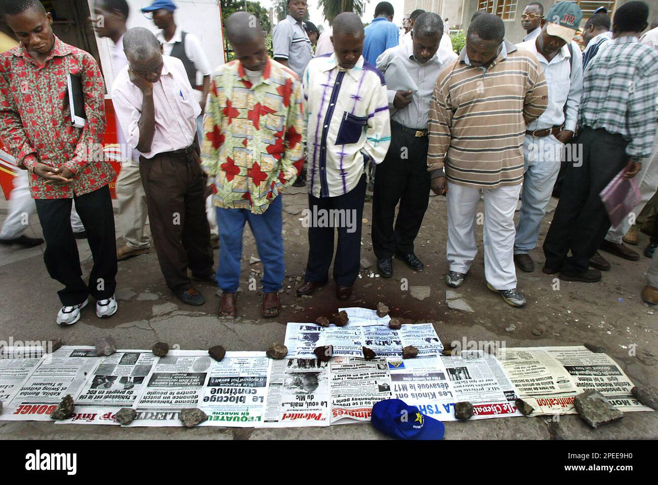 People look at newspapers at a makeshift news stand in the street of ...