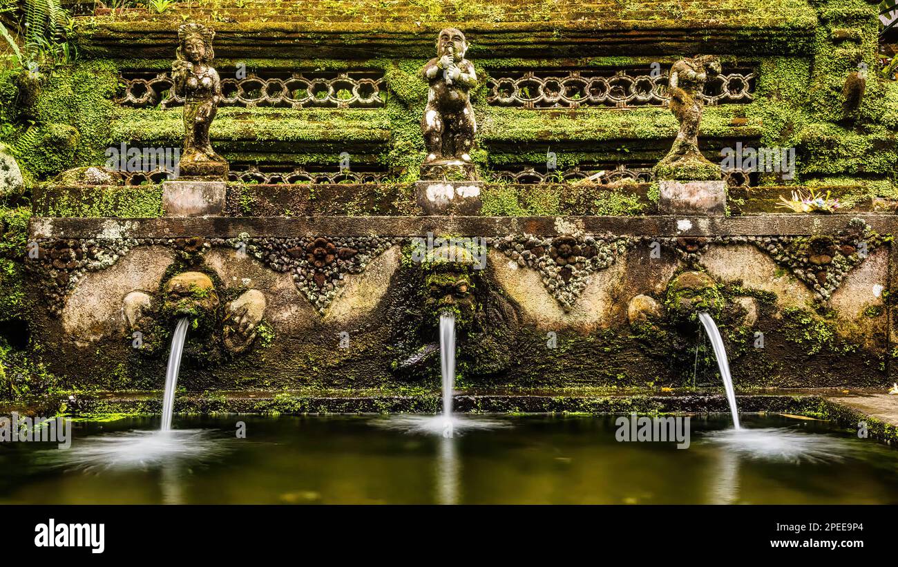 A stone monkey statue with a long neck stands beside a fountain in Pura ...