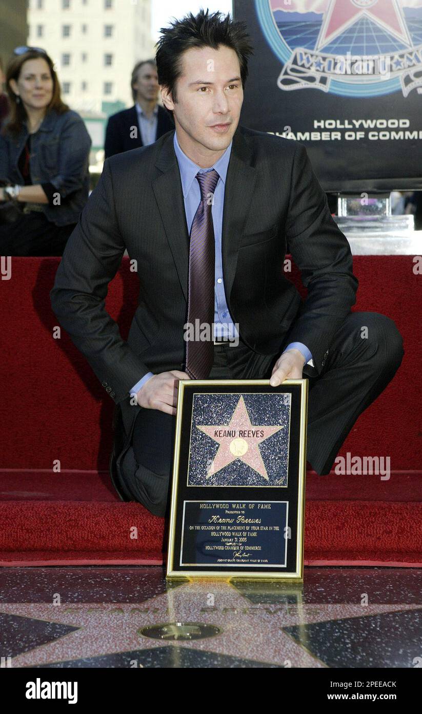 Keanu Reeves displays a plaque over the star he received during a ...