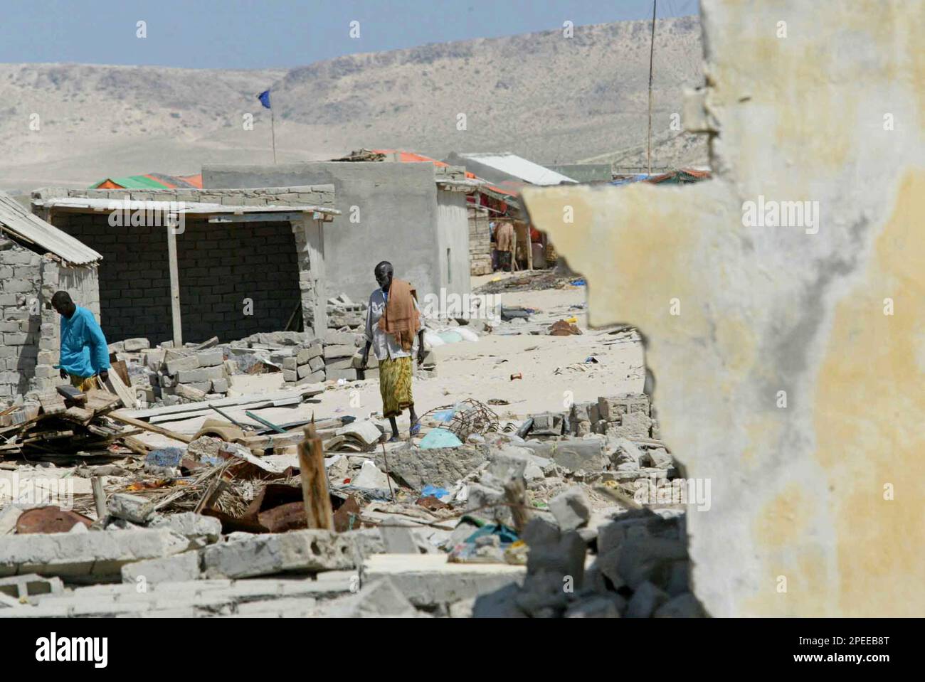 Somali's walk through the rubble of their home's, Monday, Jan. 31, 2005 ...