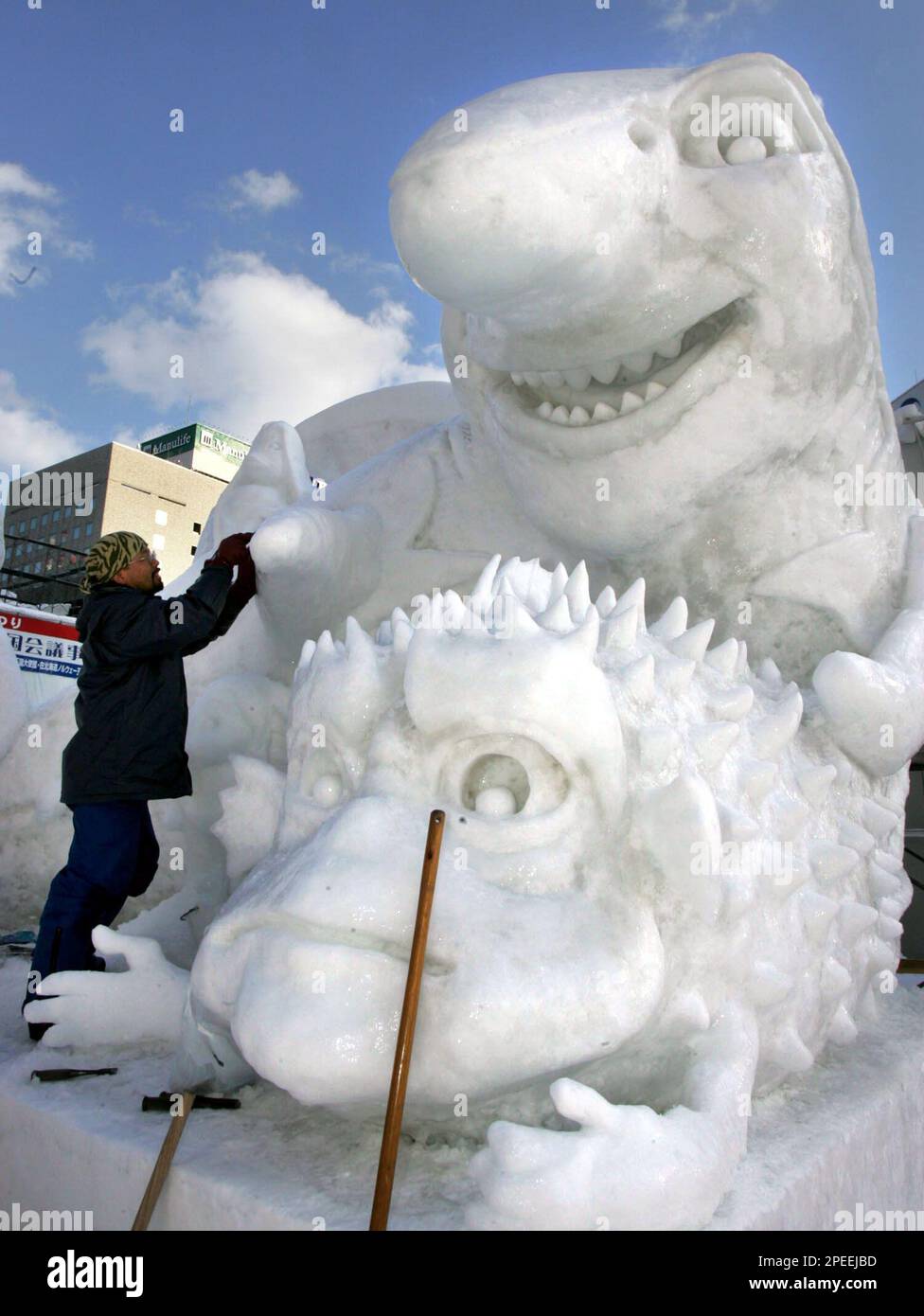 Local volunteer Atsushi Matsuo straightens snow figures of popular ...