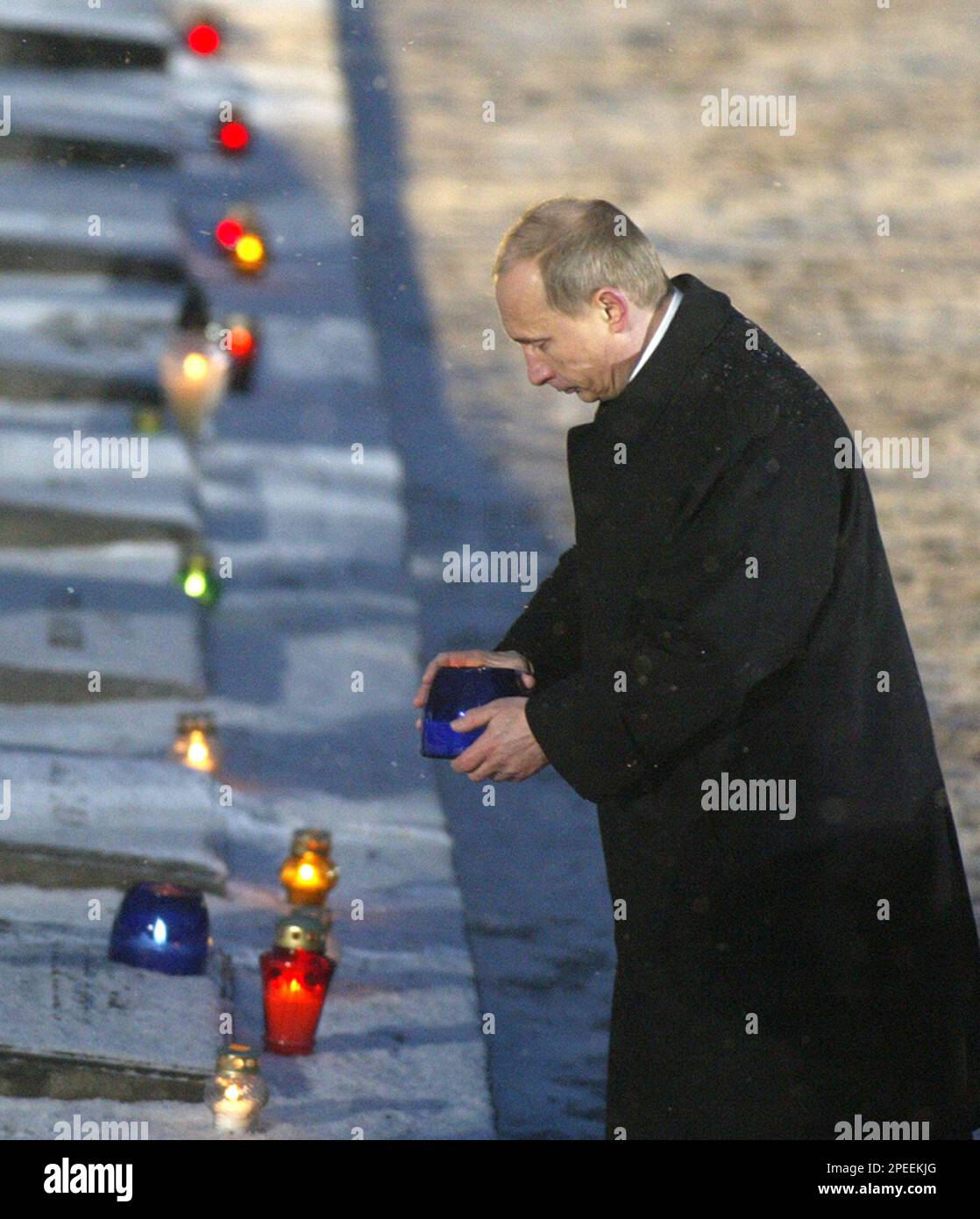 Russian President Vladimir Putin places a candle during the ceremony ...