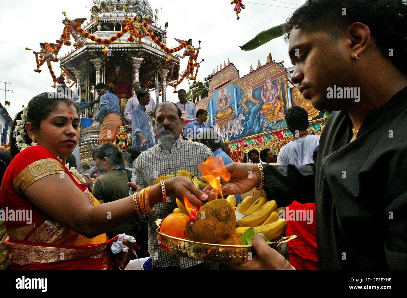 Malaysian Hindu devotee hands over offering to a priest, center, on ...