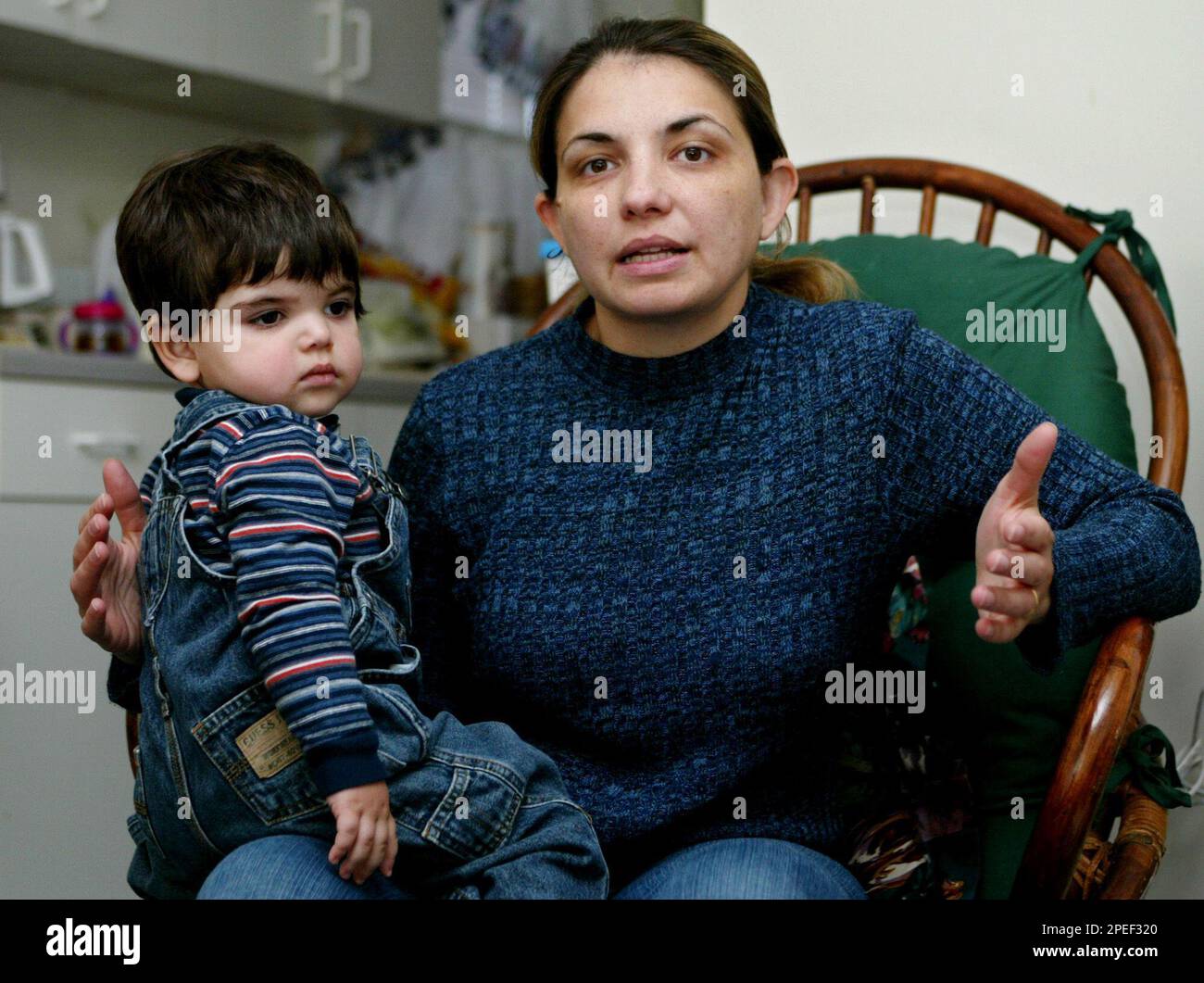 Ban Adil Sarhan holds her15-month-old son Fadi Abdul Ghani in her ...