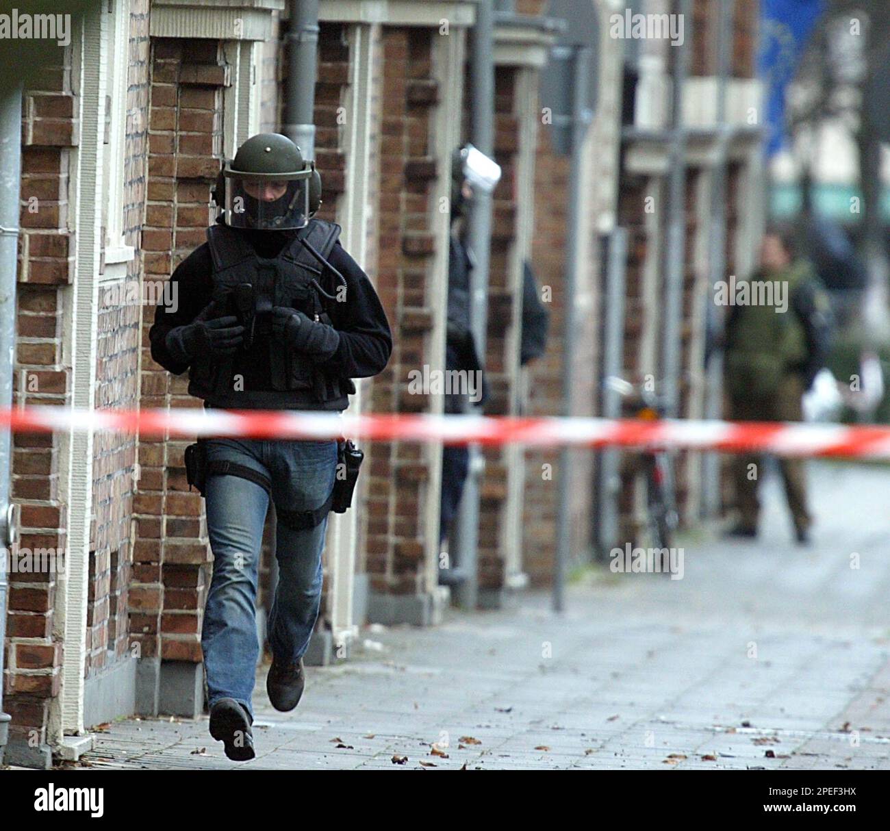 A member of the German special police force in protection gear runs ...