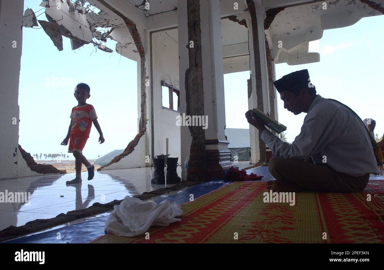 A local villager reads verses from the Quran at the tsunami-damaged Al ...