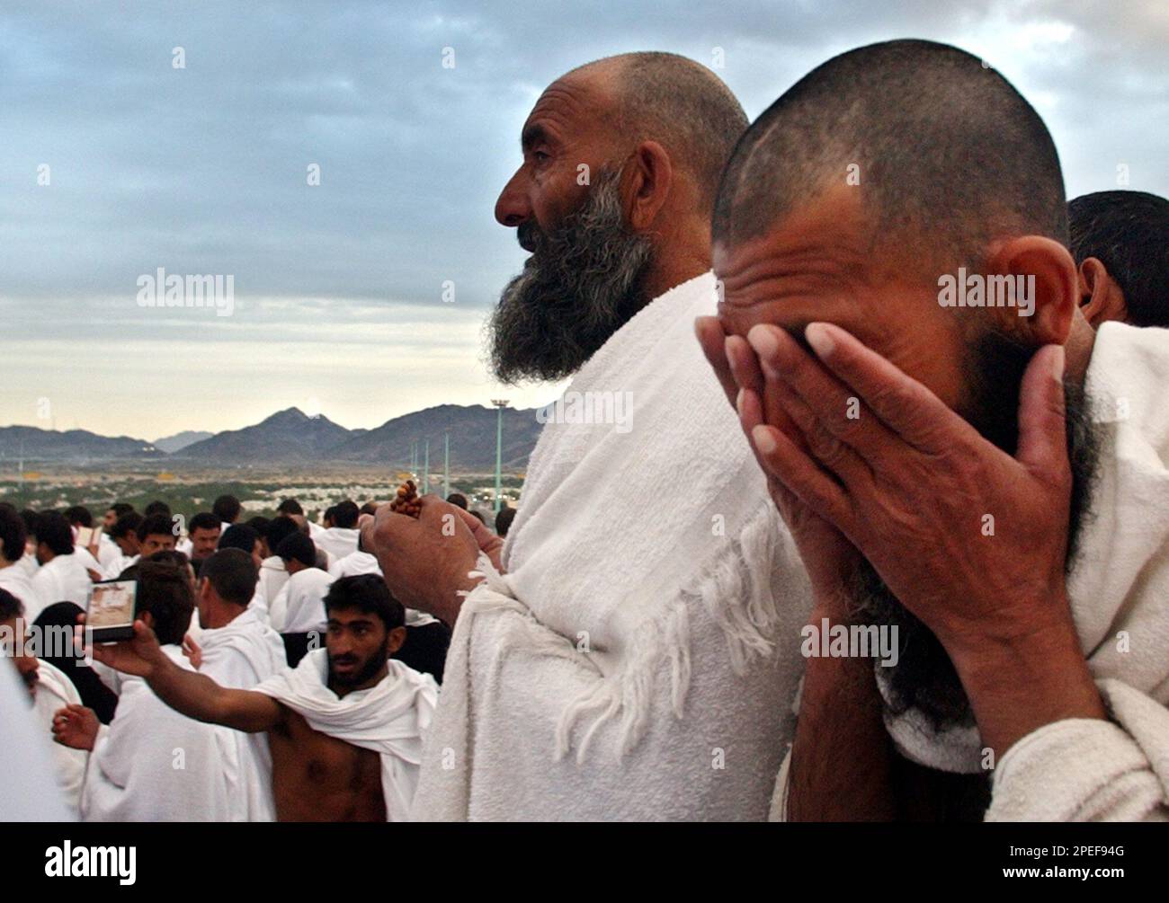 A pilgrims prays at Jabal Al Rahma holy mountain, the mountain of ...