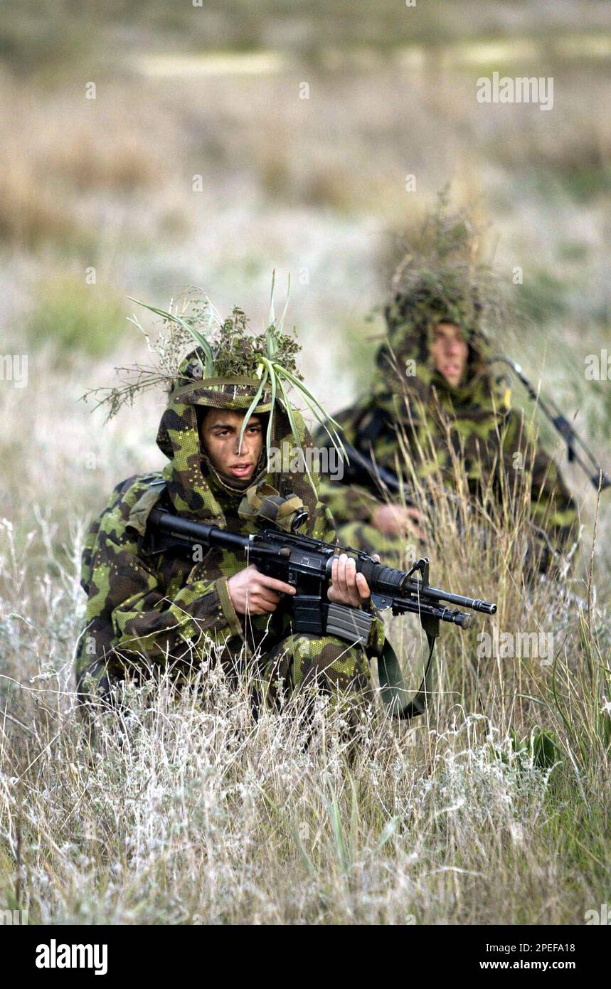 Israeli soldiers in camouflage uniforms walk in a field during an ...