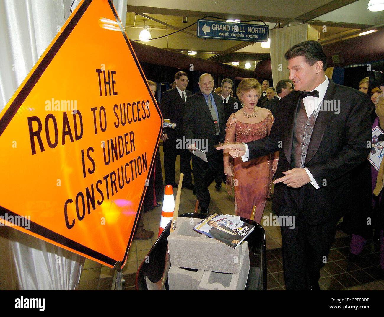 West Virginia Gov. Joe Manchin, right, points to a road sign bearing ...