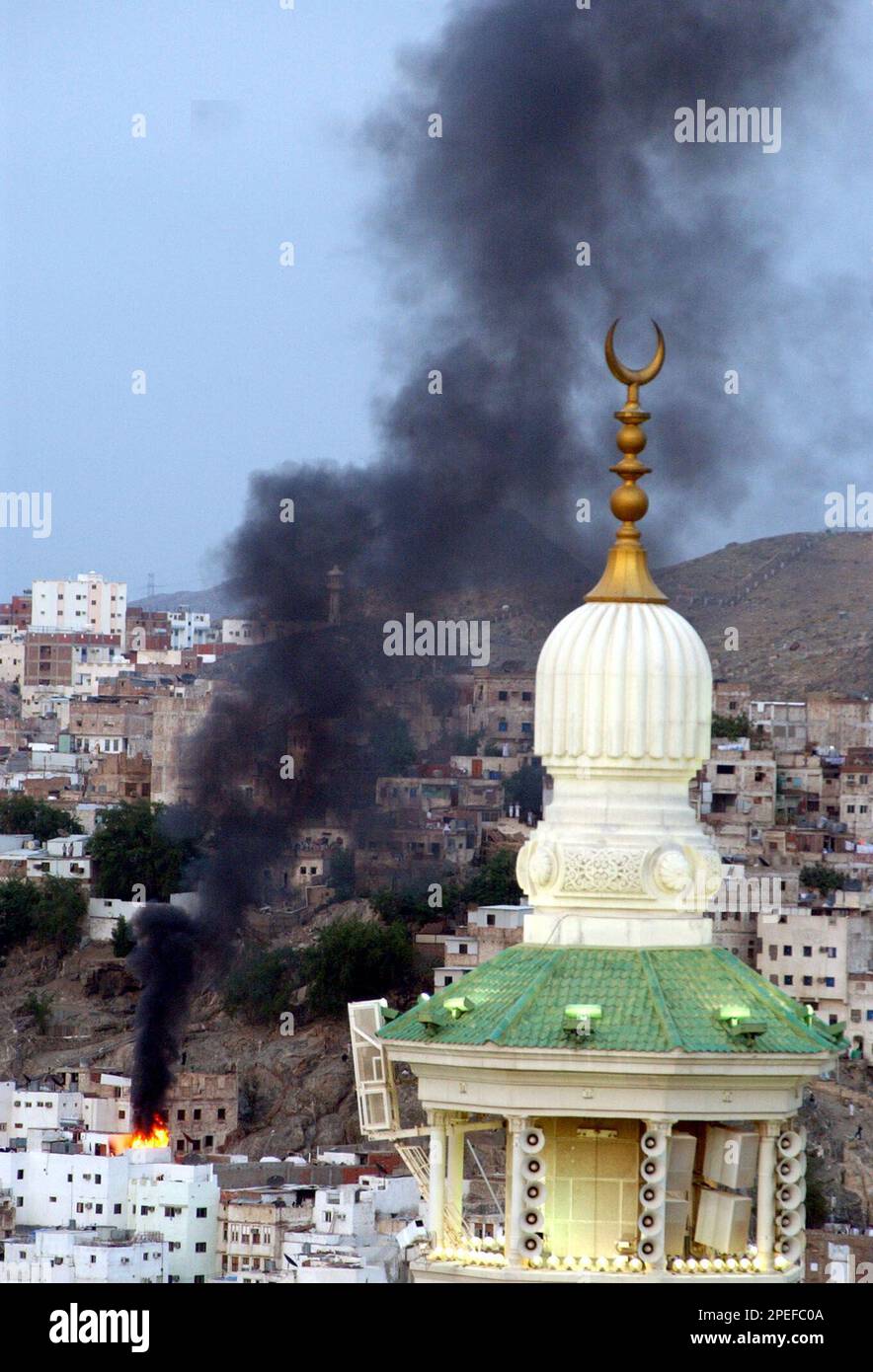 Flames and black smoke is seen rising from an apartment building behind ...