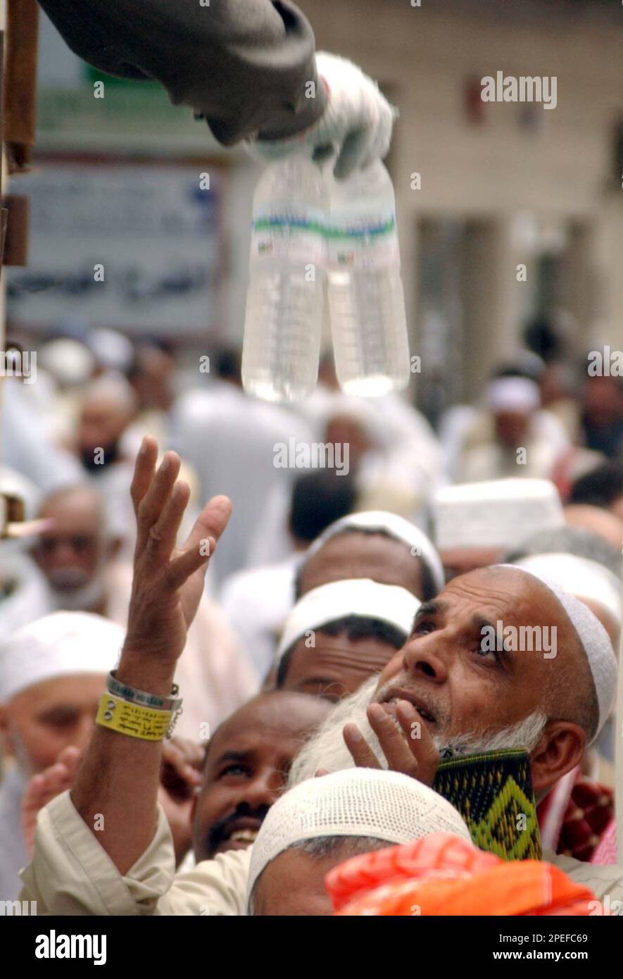Pilgrims receive free water distributed by the Saudi government at the ...