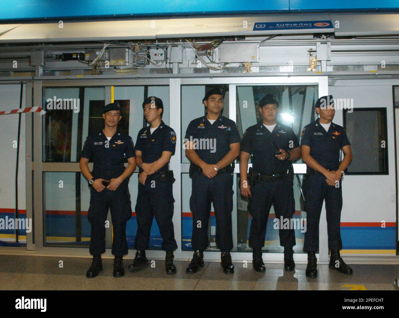 Security officers stand guard in front of a subway train damaged in an ...
