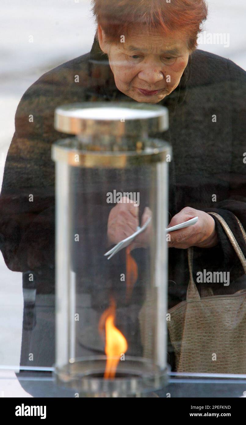 Ritsuko Hatanaka, 81, jots down words at "the Light of Hope" monument ...