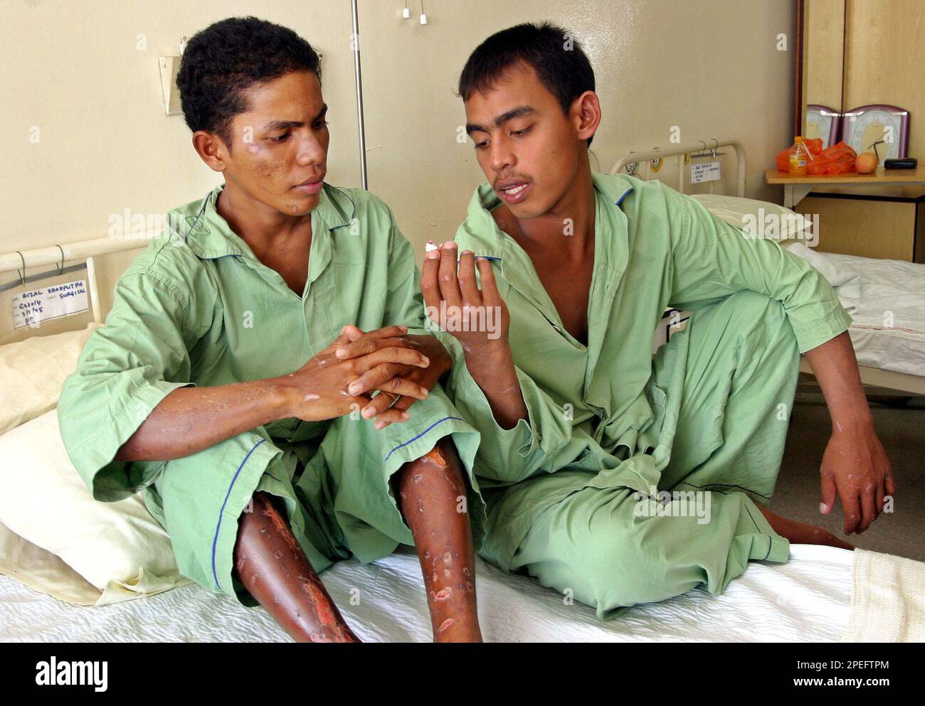 Tsunami survivor, Indonesian Ari Afrizal, right, gives a sweet to his ...