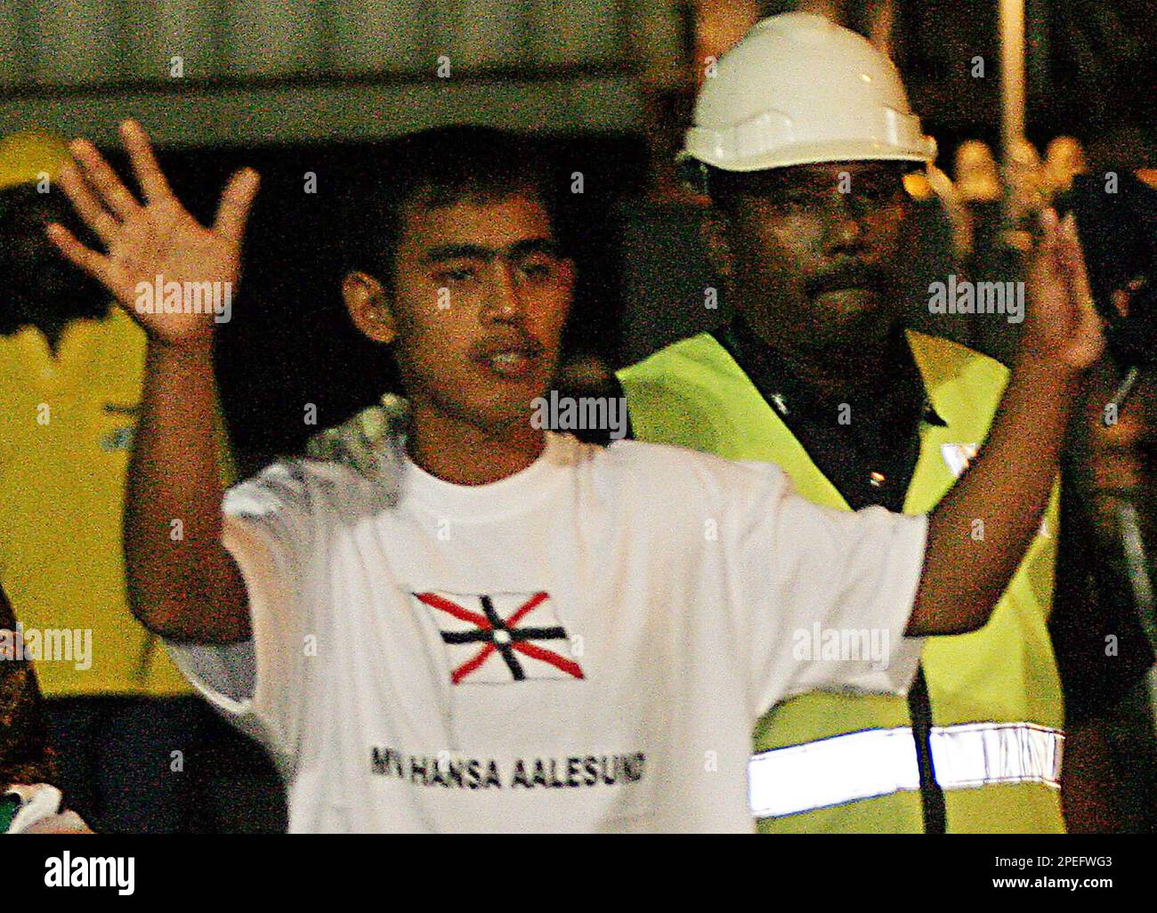 Tsunami survivor Indonesian Ari Afrizal waves while escorted by medical ...