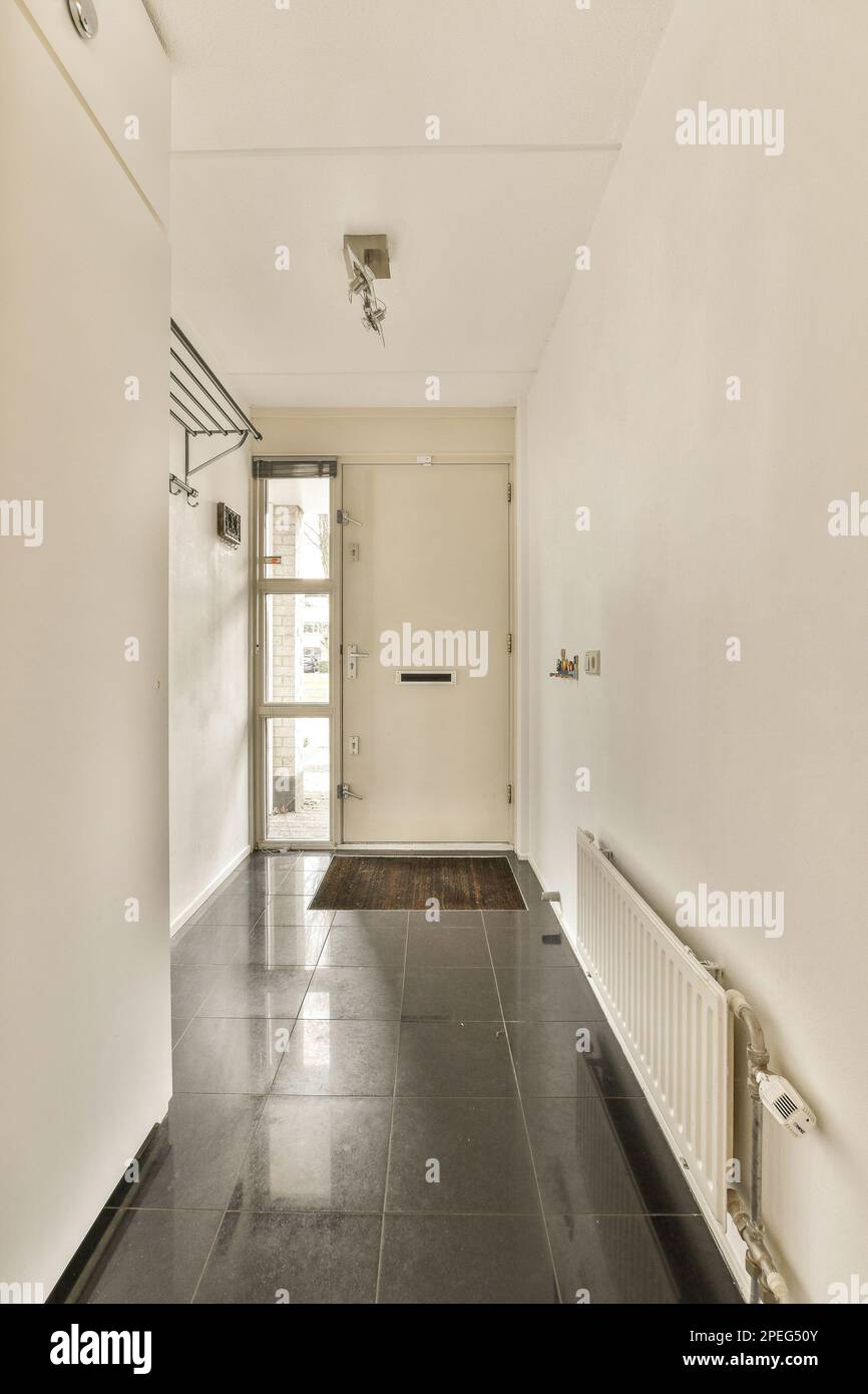 a long hallway with black tiles on the floor and white walls in an ...