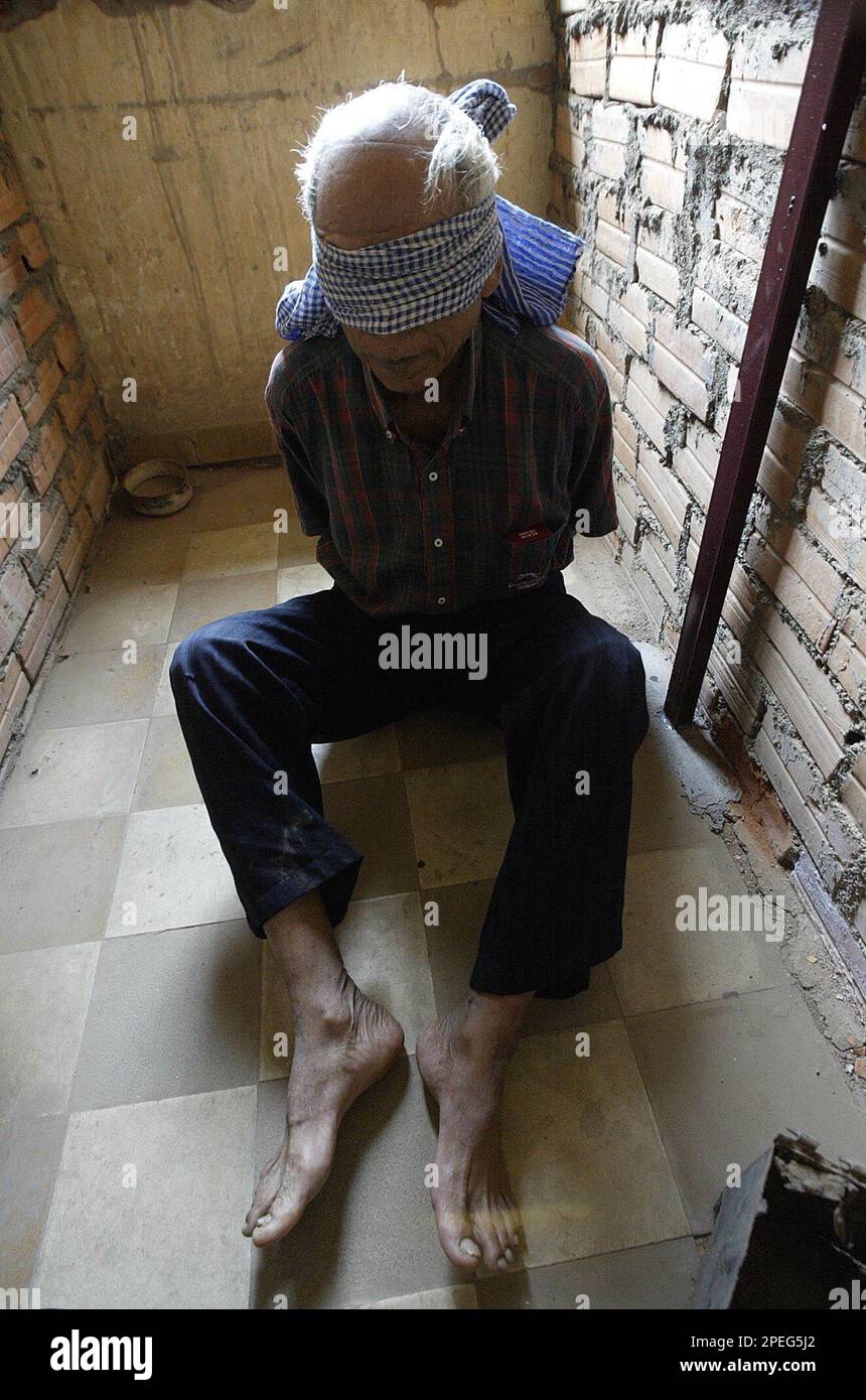 Chum Mey, 72-year-old former prisoner of the Khmer Rouge, demonstrates ...