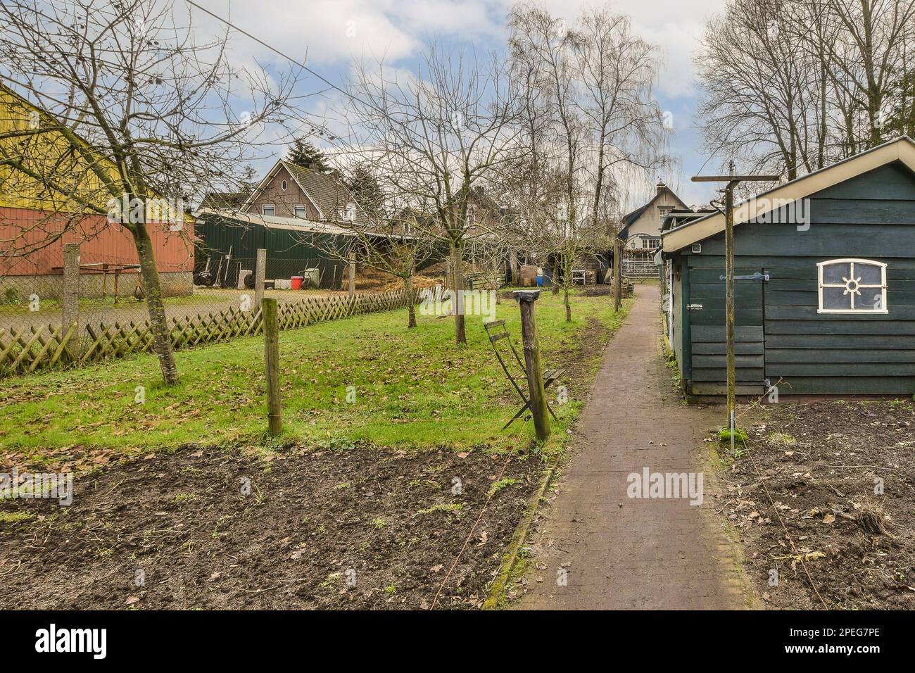 a small house on the side of a road with trees in the background and an ...