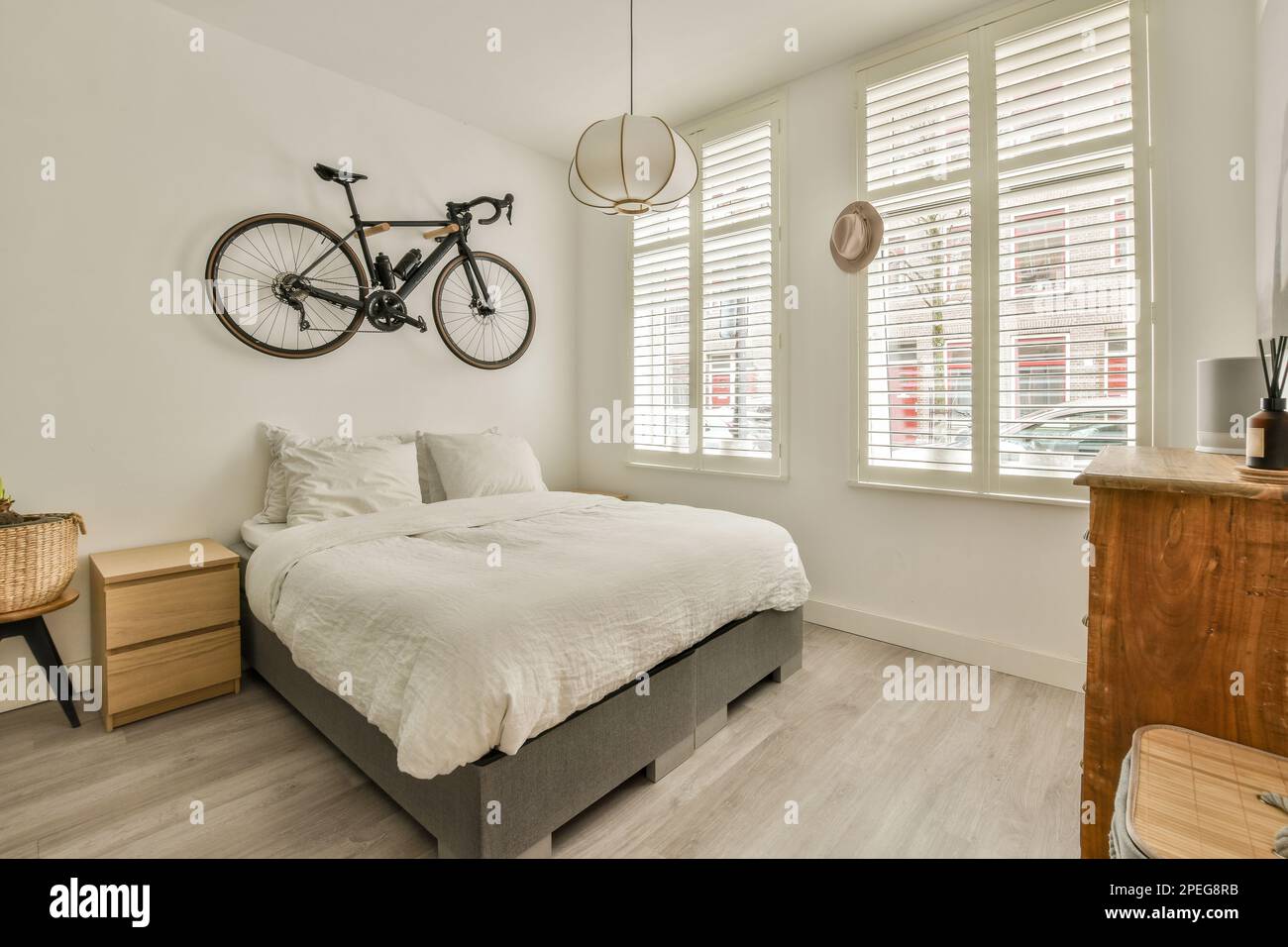 a bedroom with a bicycle mounted on the wall above it and a bed in the ...