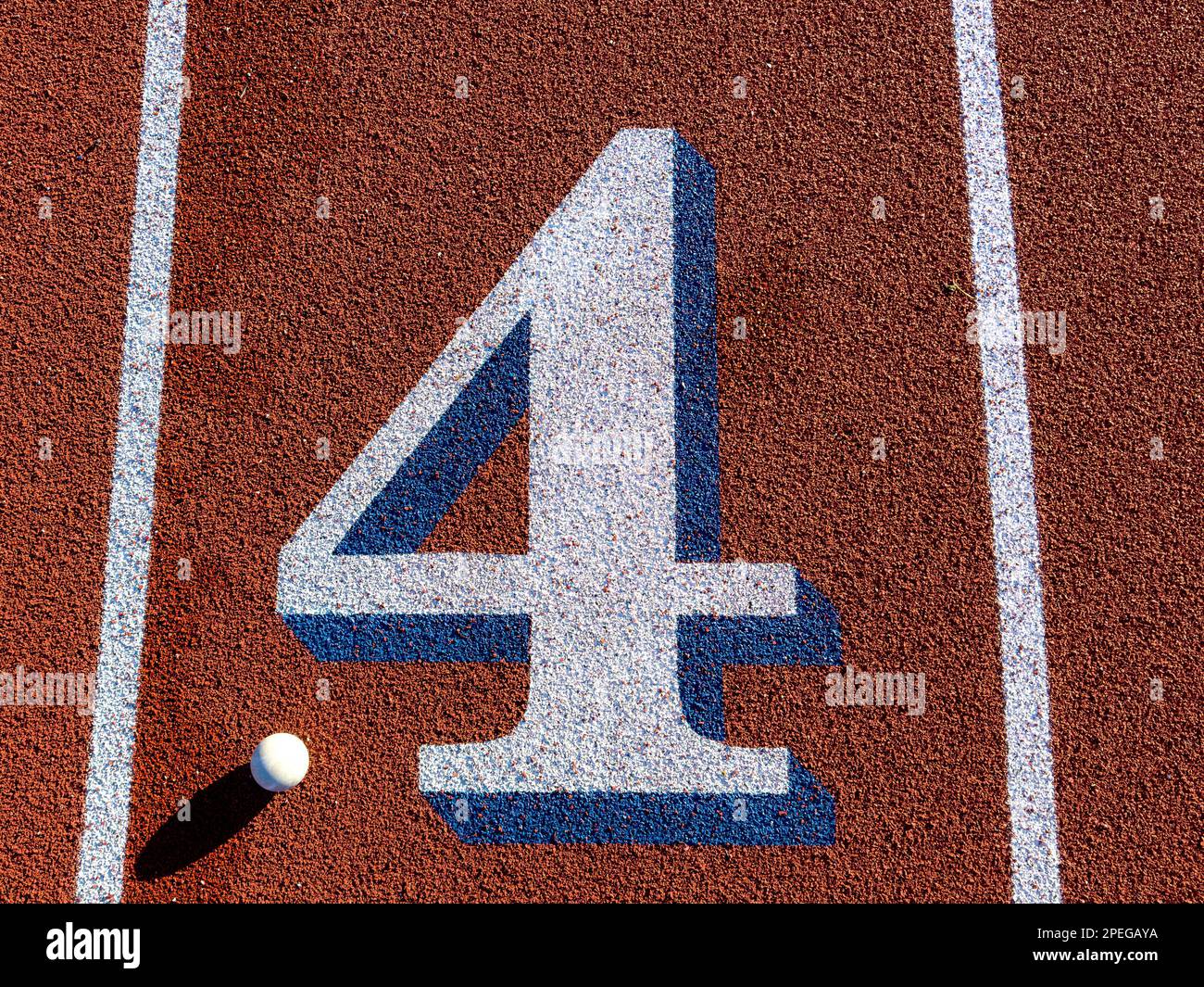 Close up lane number 4 on a new red running track with white lane lines ...
