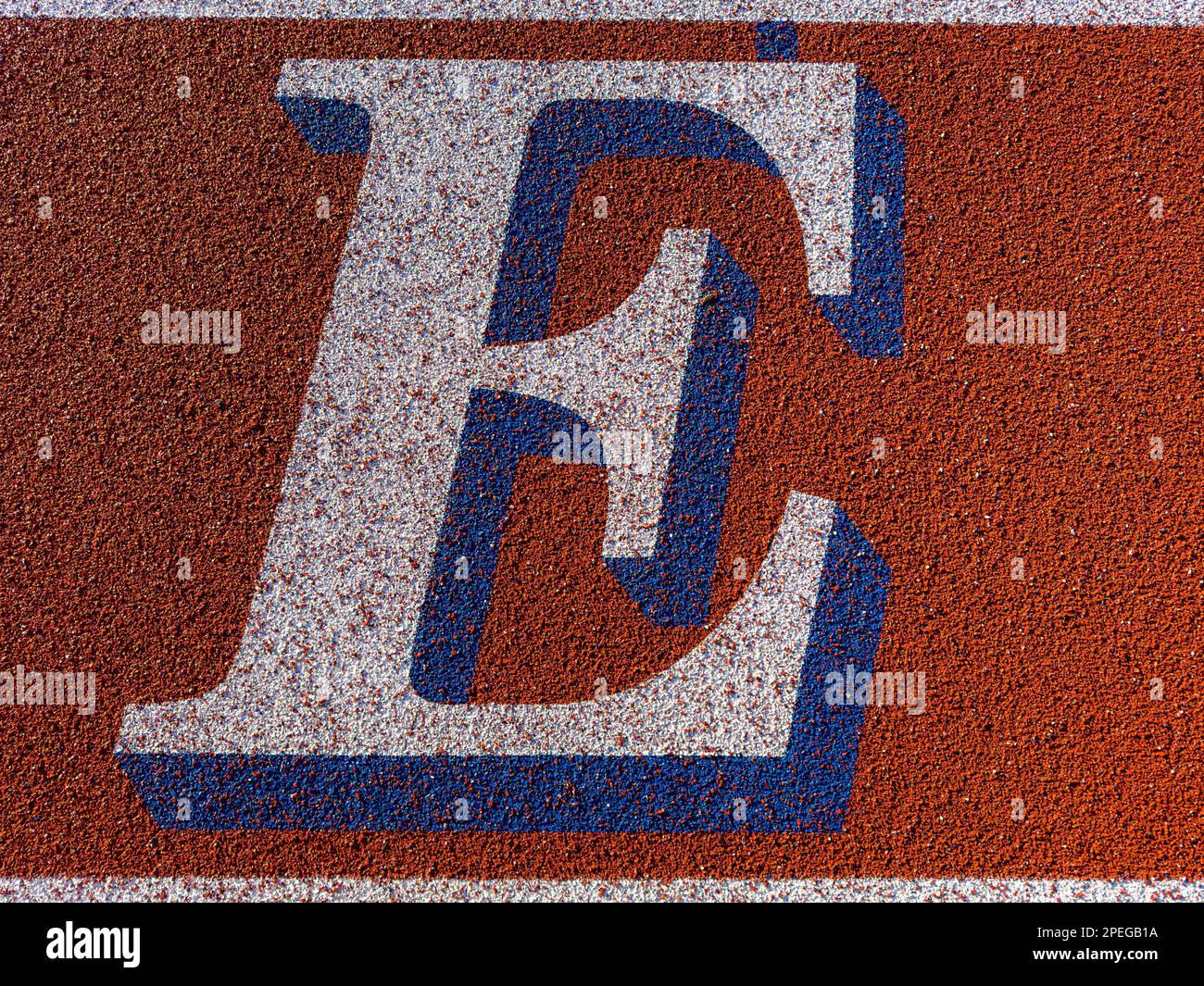 Close up of the letter E on new red running track with white lane lines ...