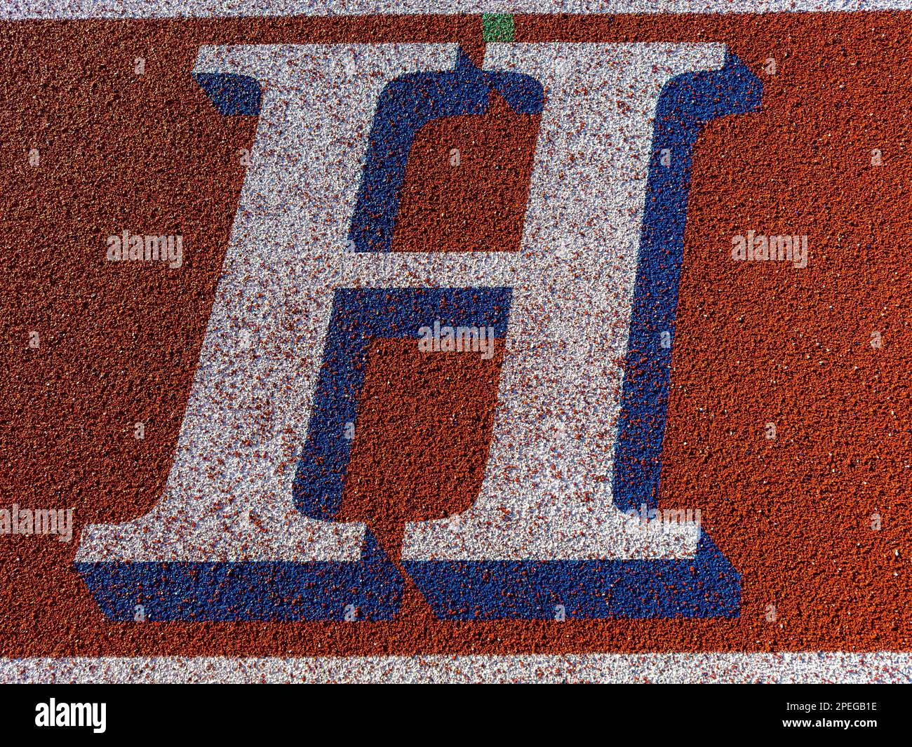 Close up of the letter H on new red running track with white lane lines ...
