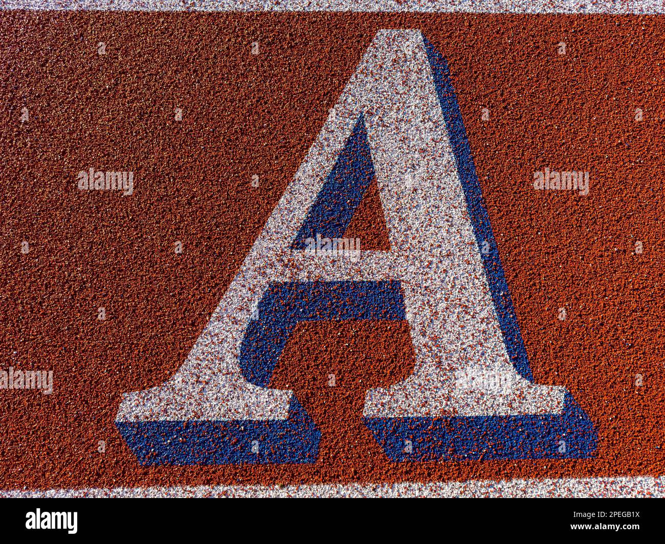 Close up of the letter A on new red running track with white lane lines ...