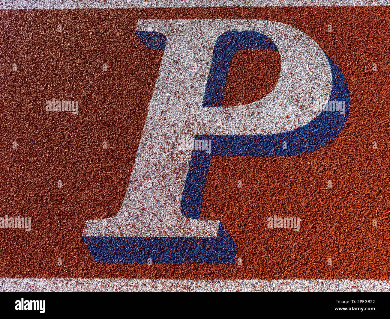 Close up of the letter P on new red running track with white lane lines ...