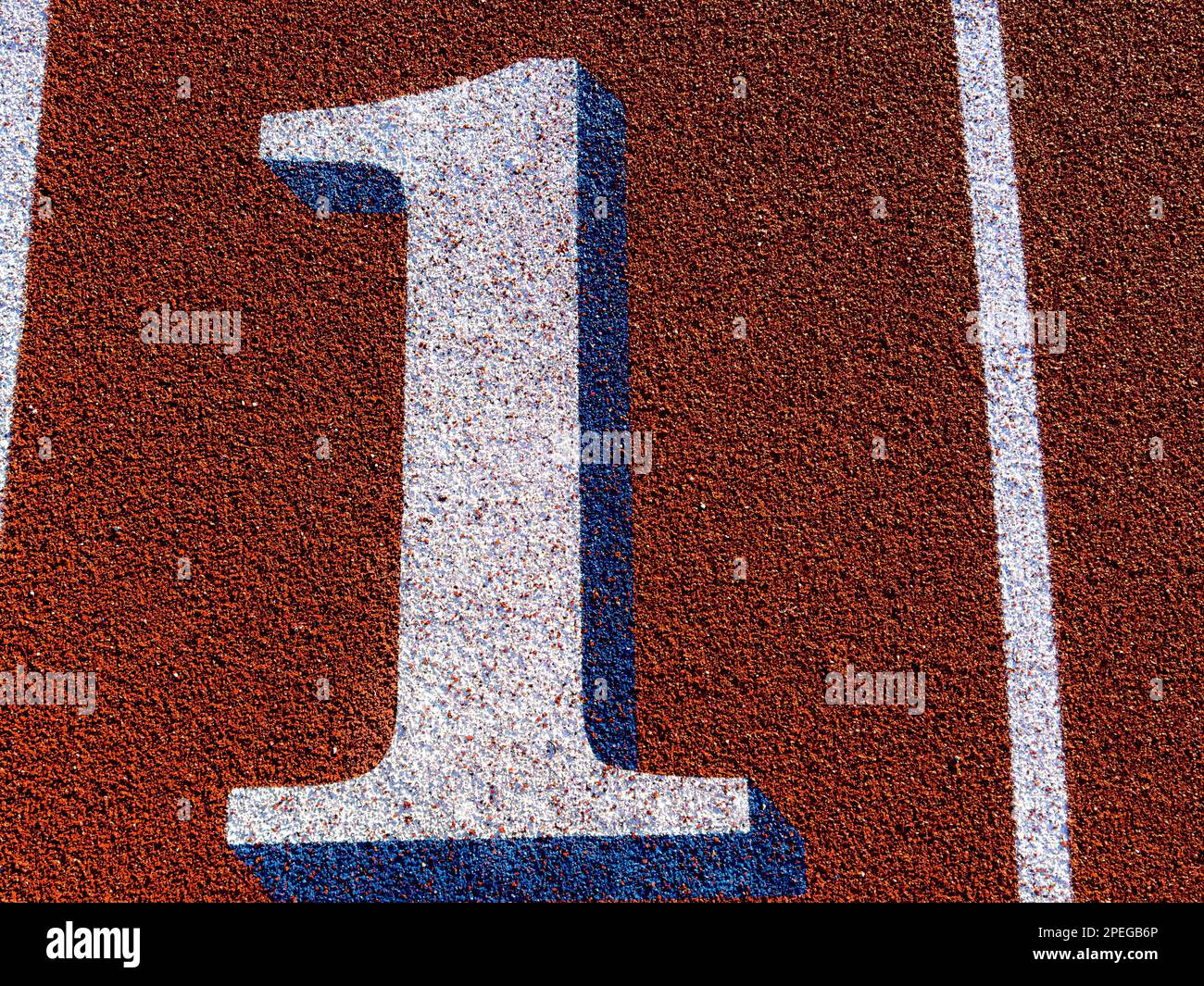 Close up lane number 1 on a new red running track with white lane lines ...