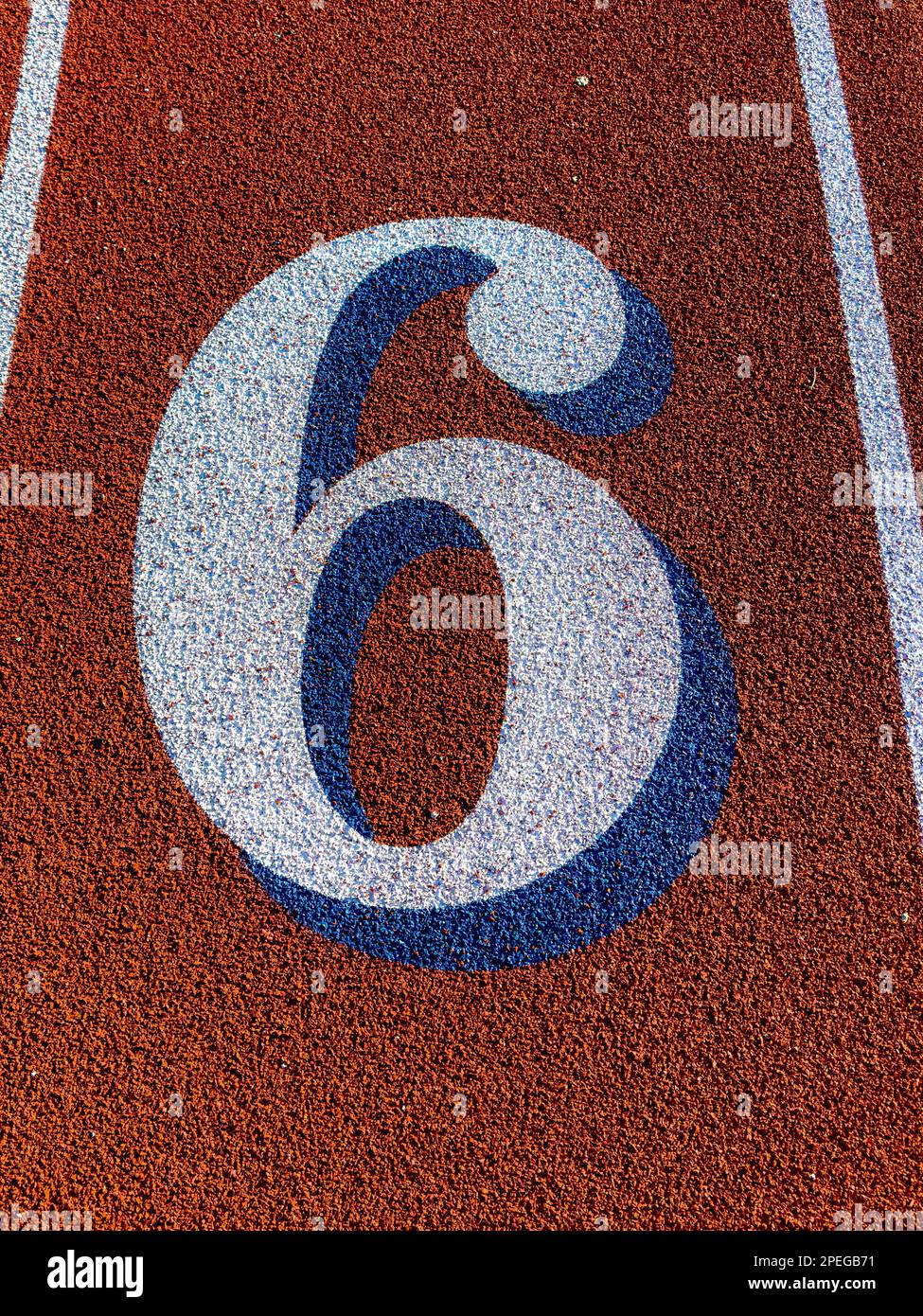 Close up lane number 6 on a new red running track with white lane lines ...