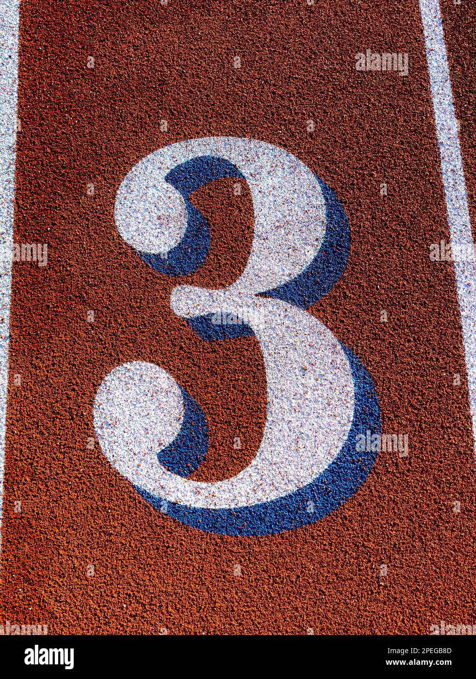 Close up lane number 3 on a new red running track with white lane lines ...