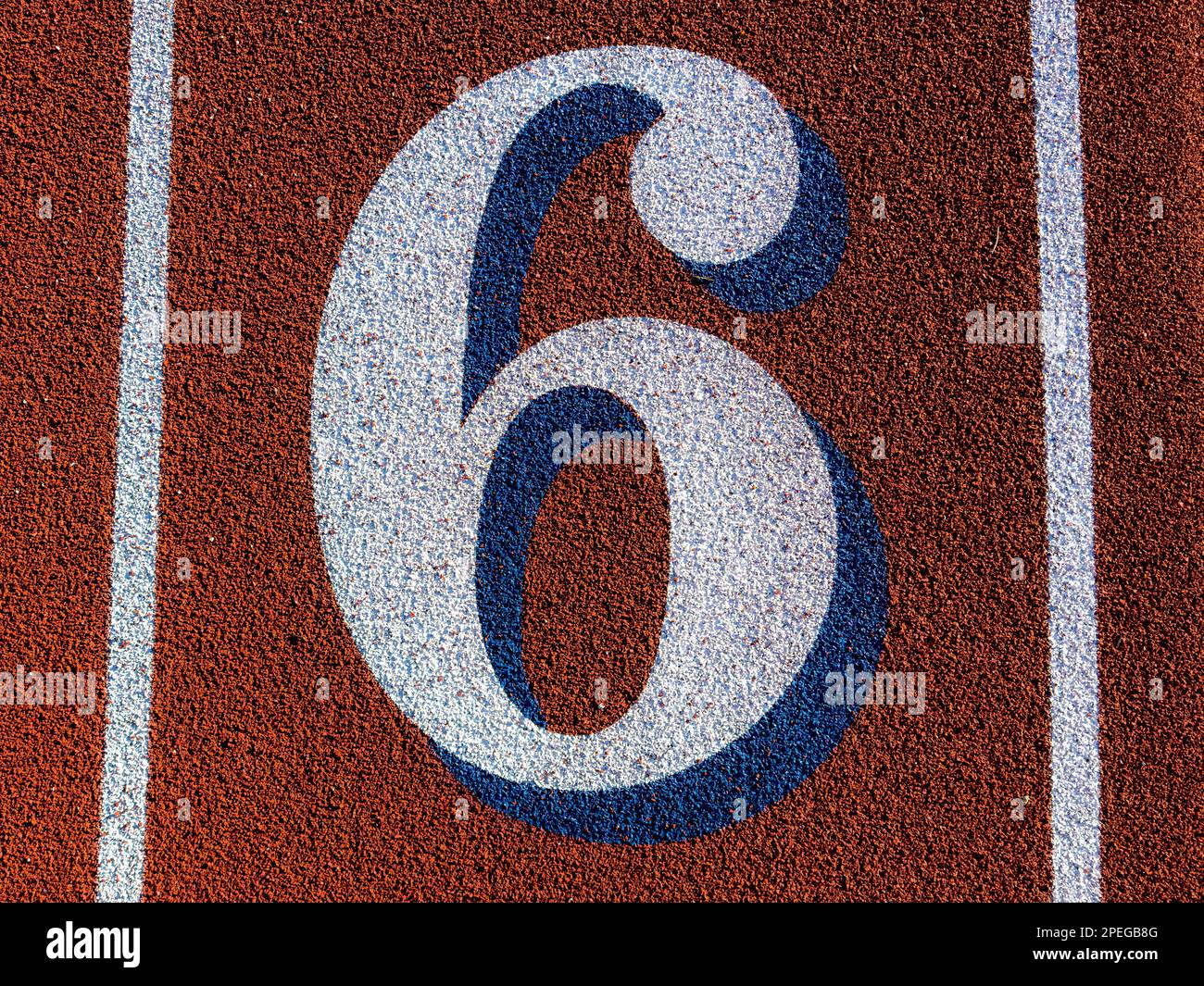 Close up lane number 6 on a new red running track with white lane lines ...