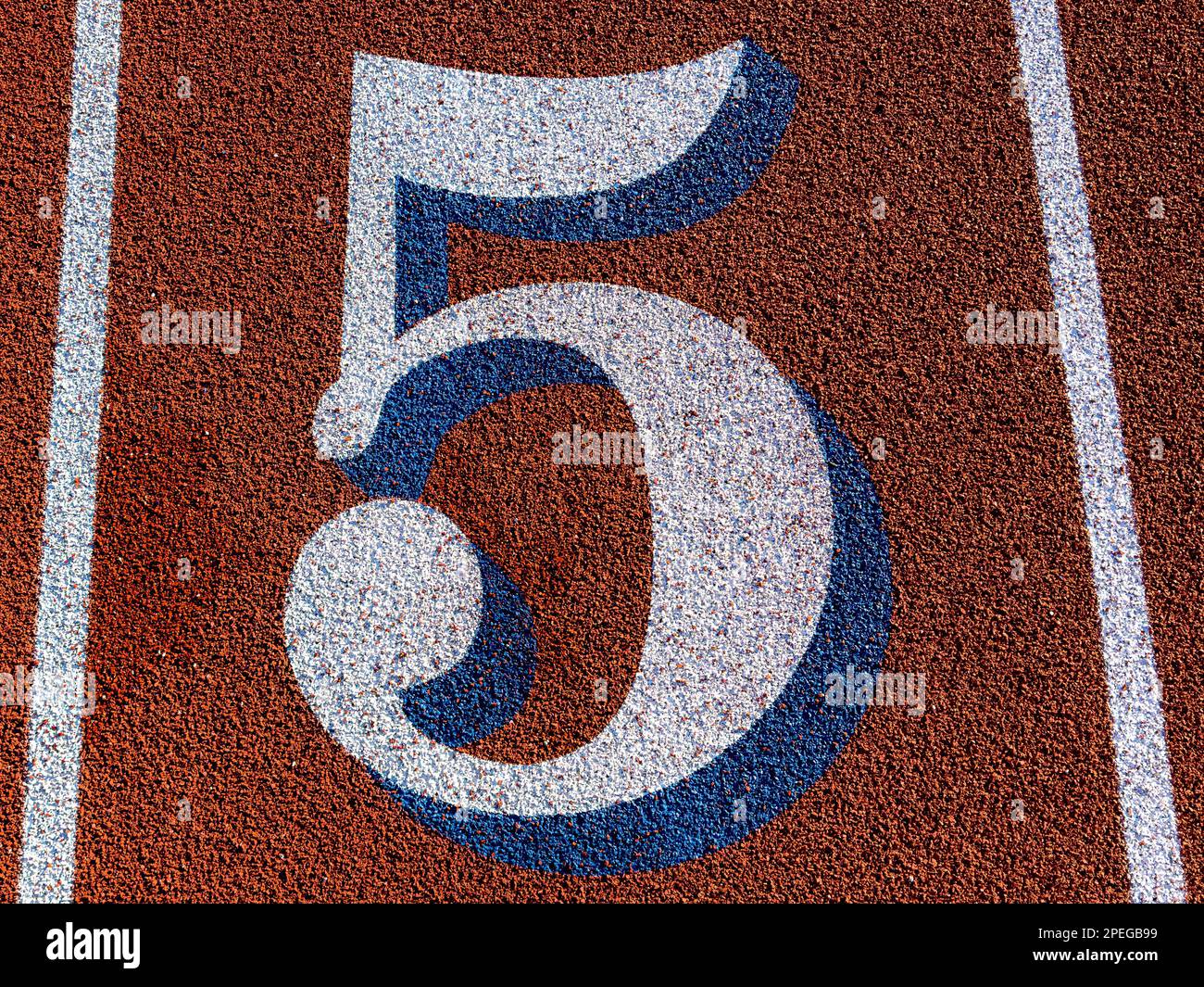 Close up lane number 5 on a new red running track with white lane lines ...