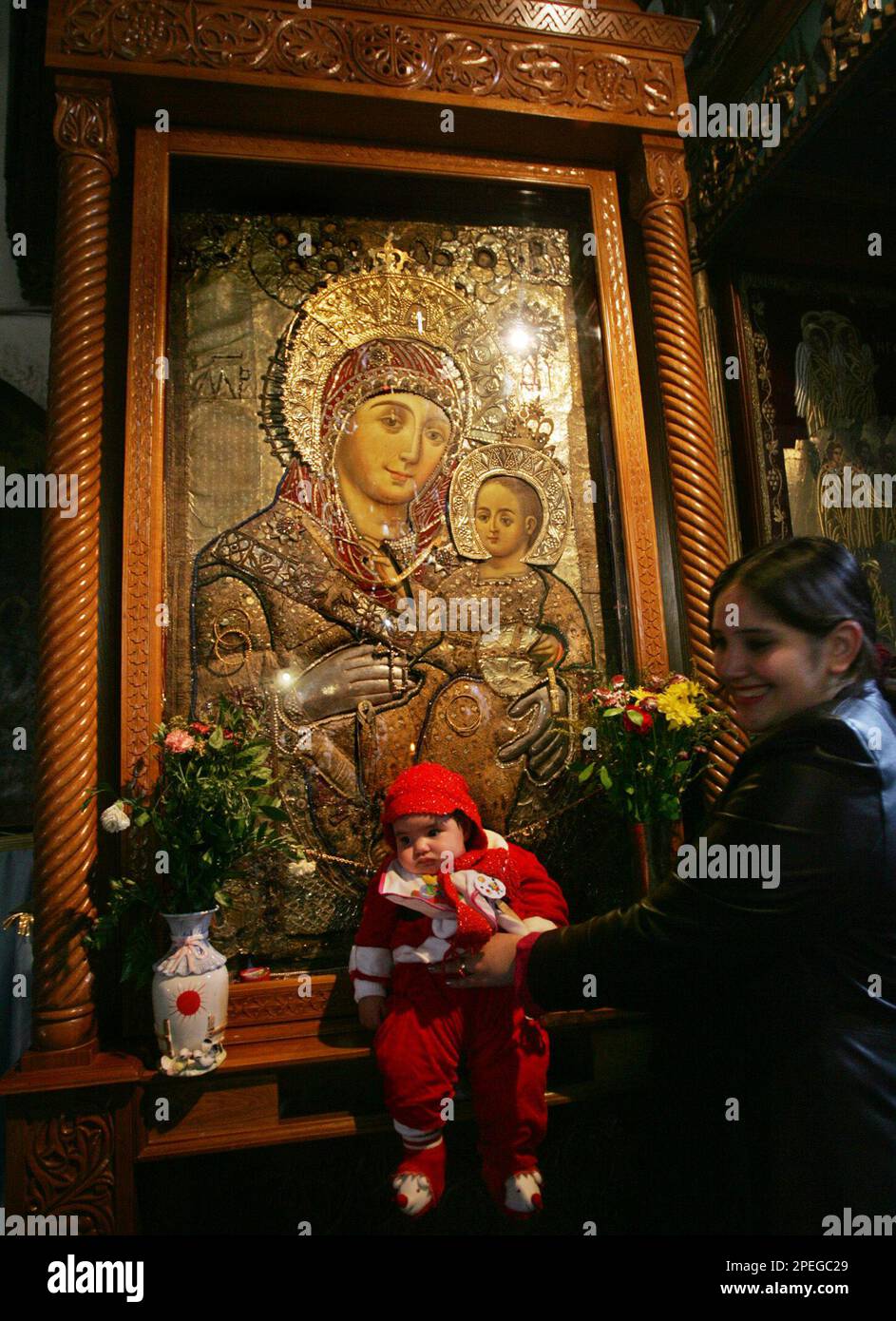 A Palestinian Christian girl is dressed like Santa Claus as she sits in ...