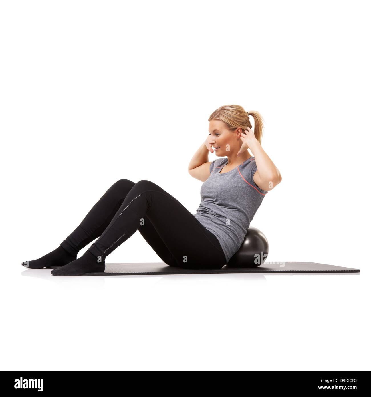 Having a toned stomach will be the reward. A young woman doing sit-ups ...