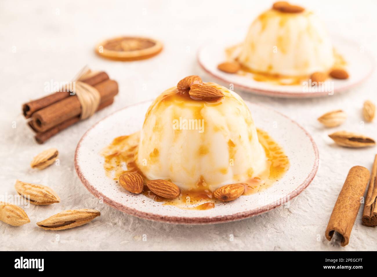 White milk jelly with caramel sauce on gray concrete background. side ...