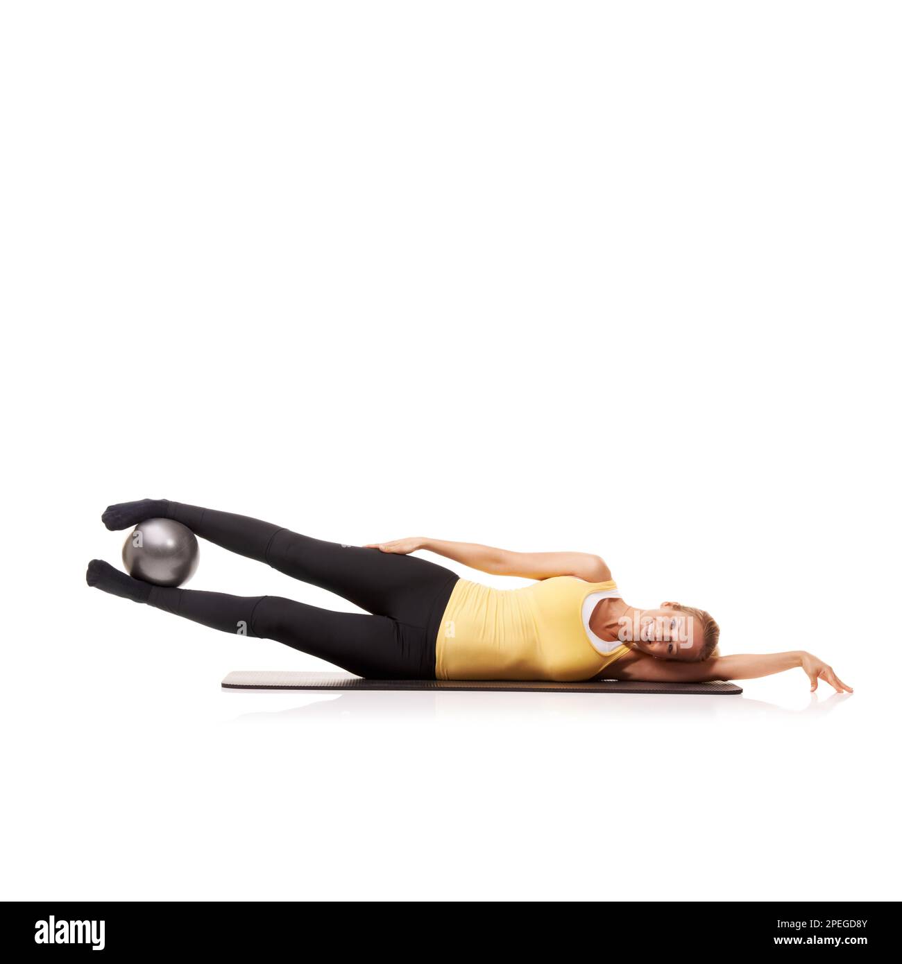 Leg-lifts with a weighted exercise ball. A pretty young woman working ...