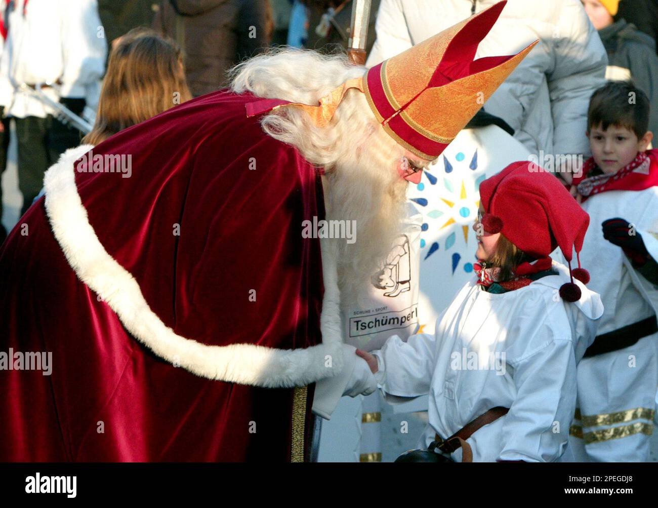 A man dressed as St. Nicholas shakes hands with a young girl during the ...