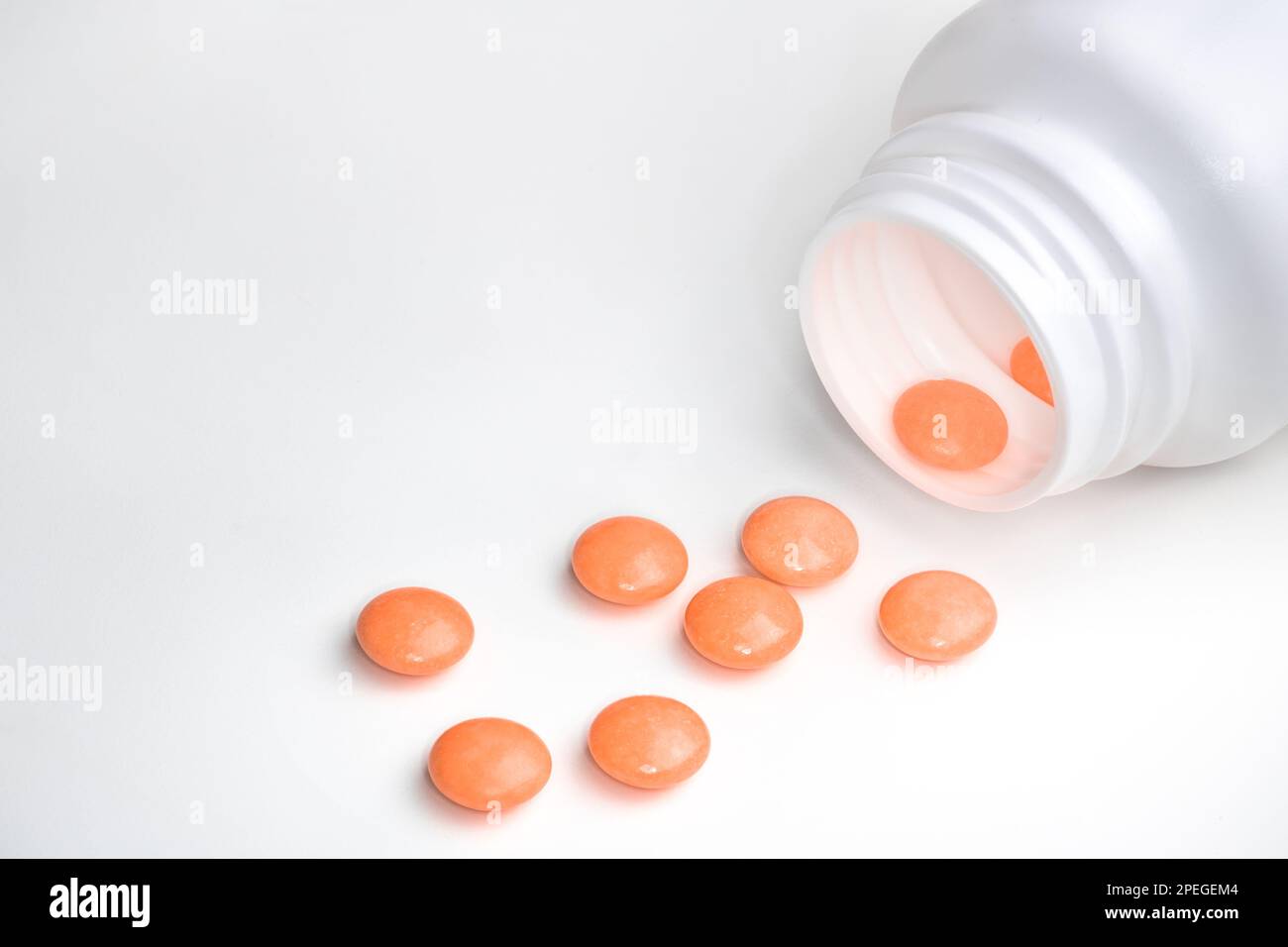 Spilled orange pills from open prescription medication plastic white ...